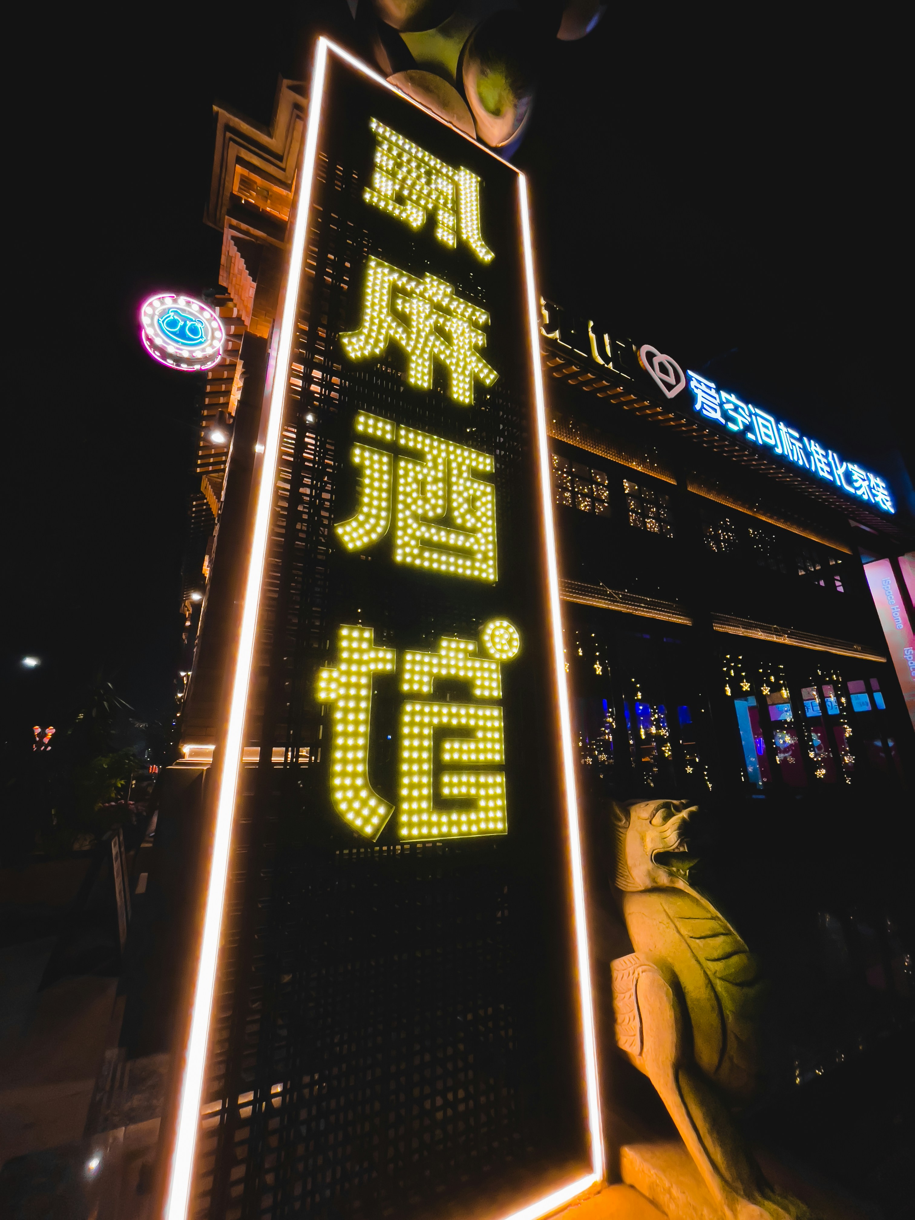 Vertical Neon Glyphs Illuminate a Nighttime Hotel Façade