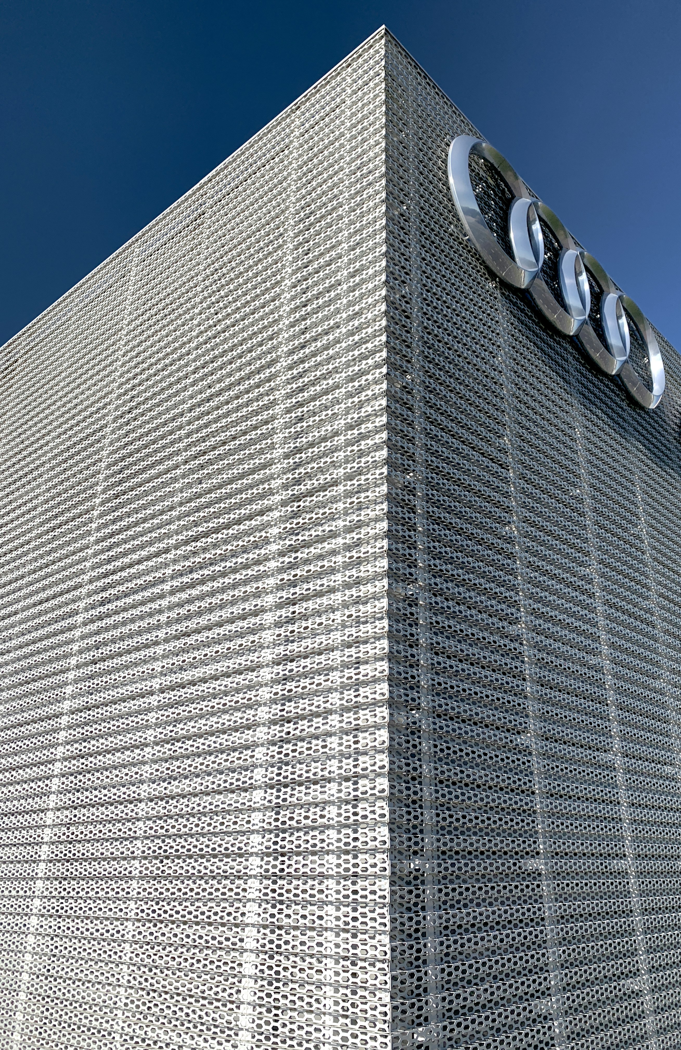 Angular Facade: Perforated Metal Walls Crowned by Circular Fixtures