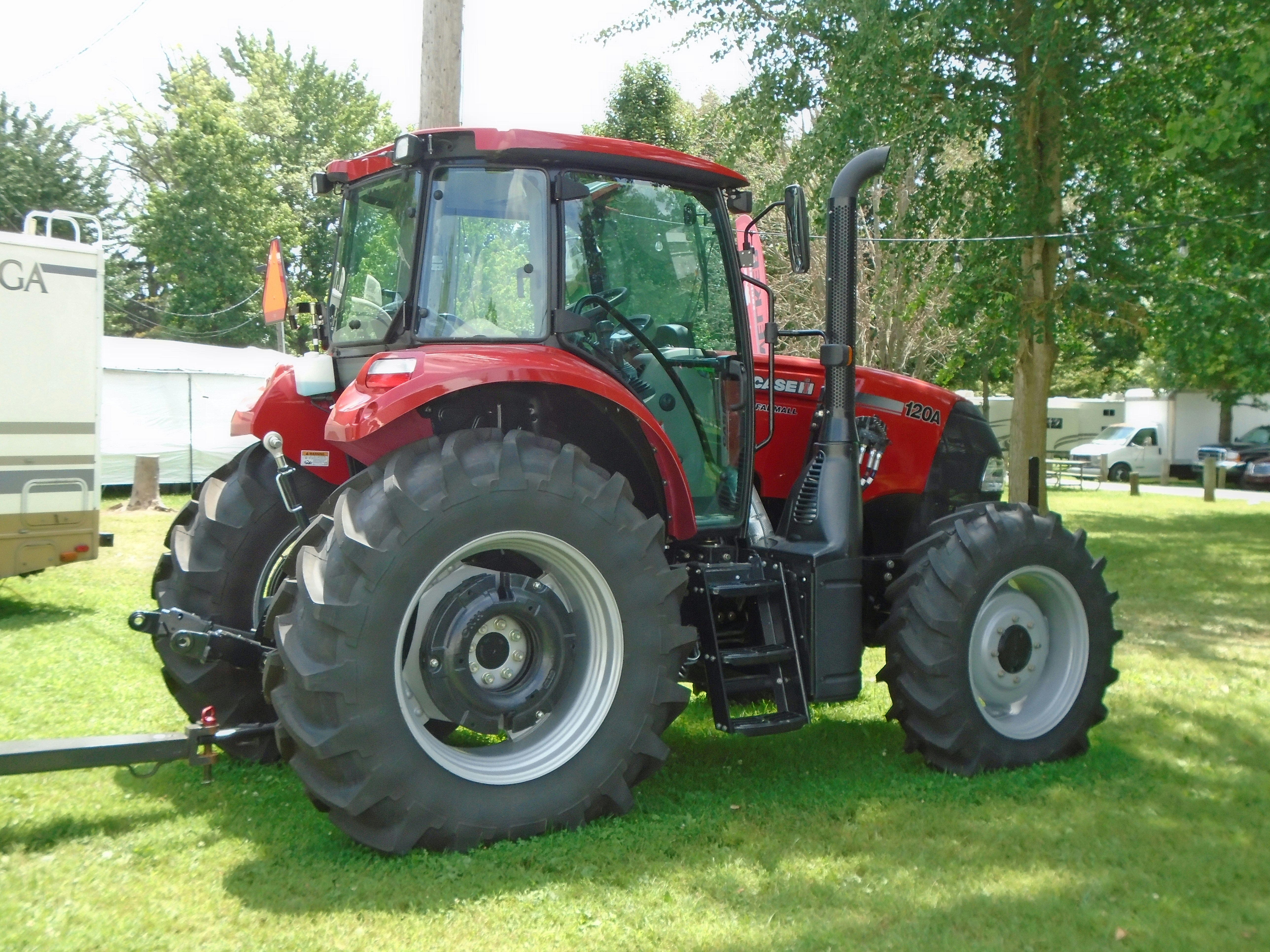 Foto Un tractor rojo estacionado en la cima de un exuberante campo ...
