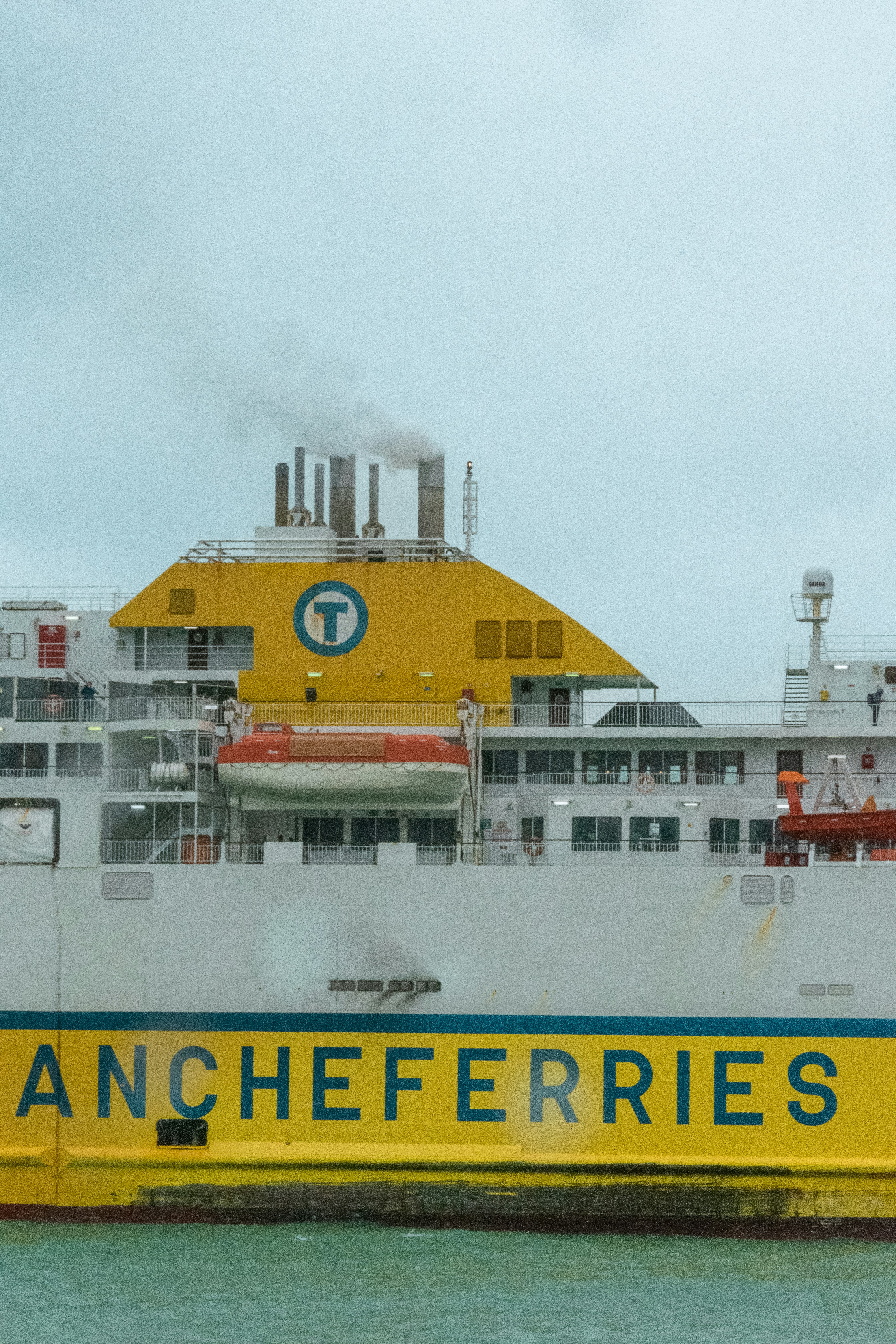 Yellow Ferry Marked by Bold Fins and Logo Against Turquoise Water