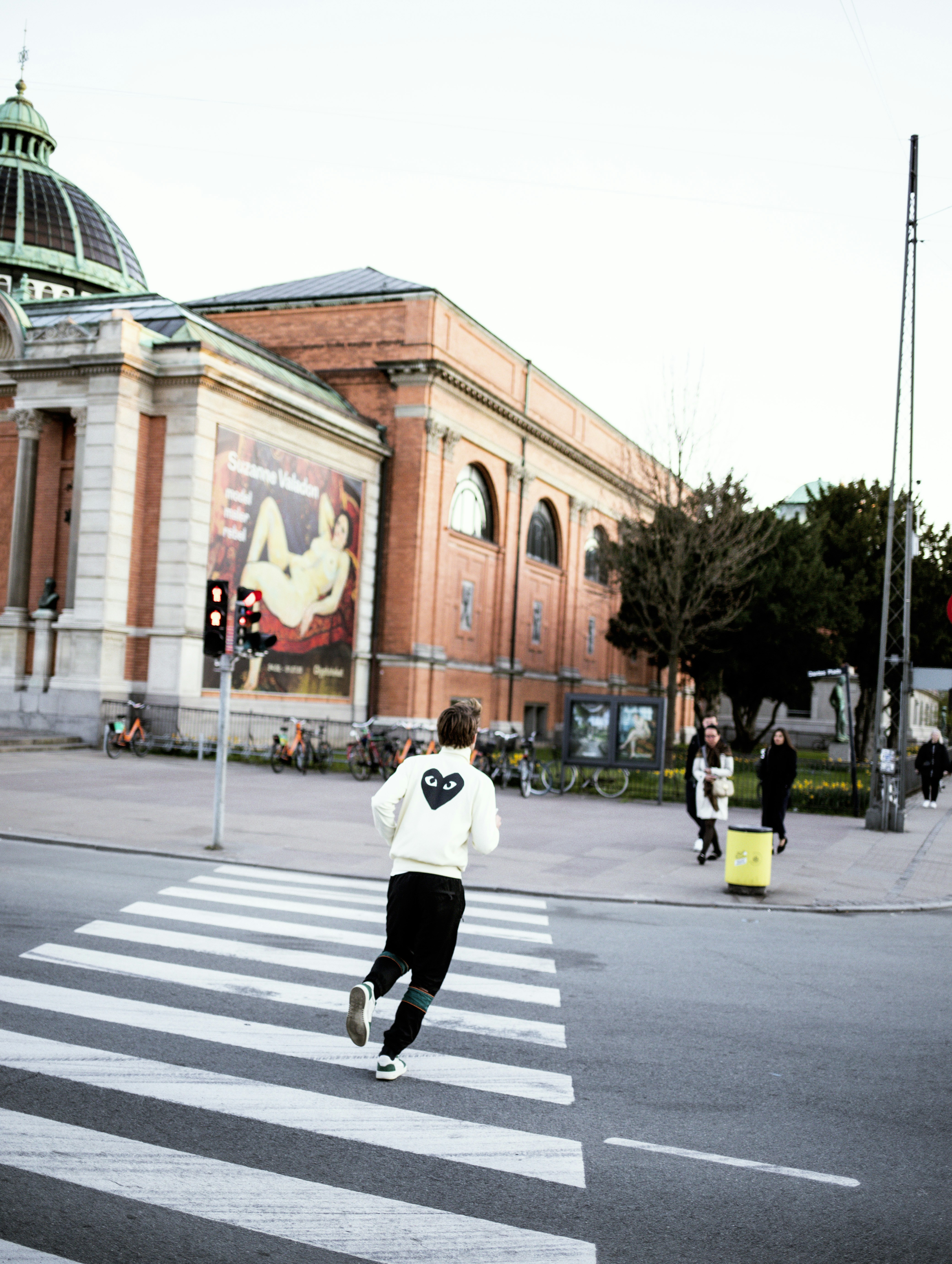 A man running across a street in front of a building photo – Free ...