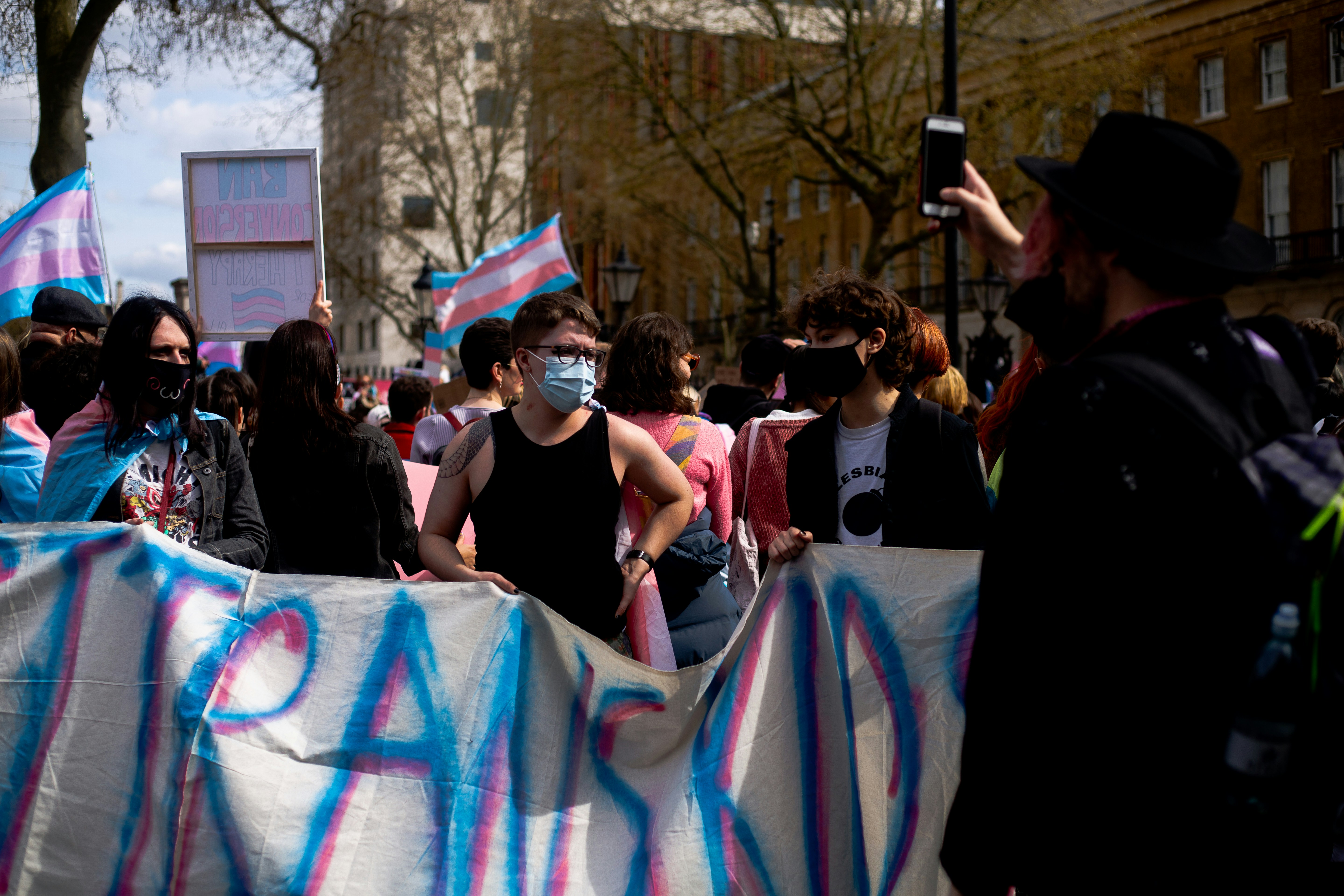 A group of people holding signs and wearing face masks photo – Free ...