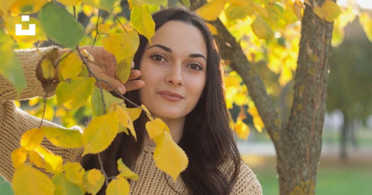 Foto Una Mujer Parada Debajo De Un árbol Con Hojas Amarillas Imagen