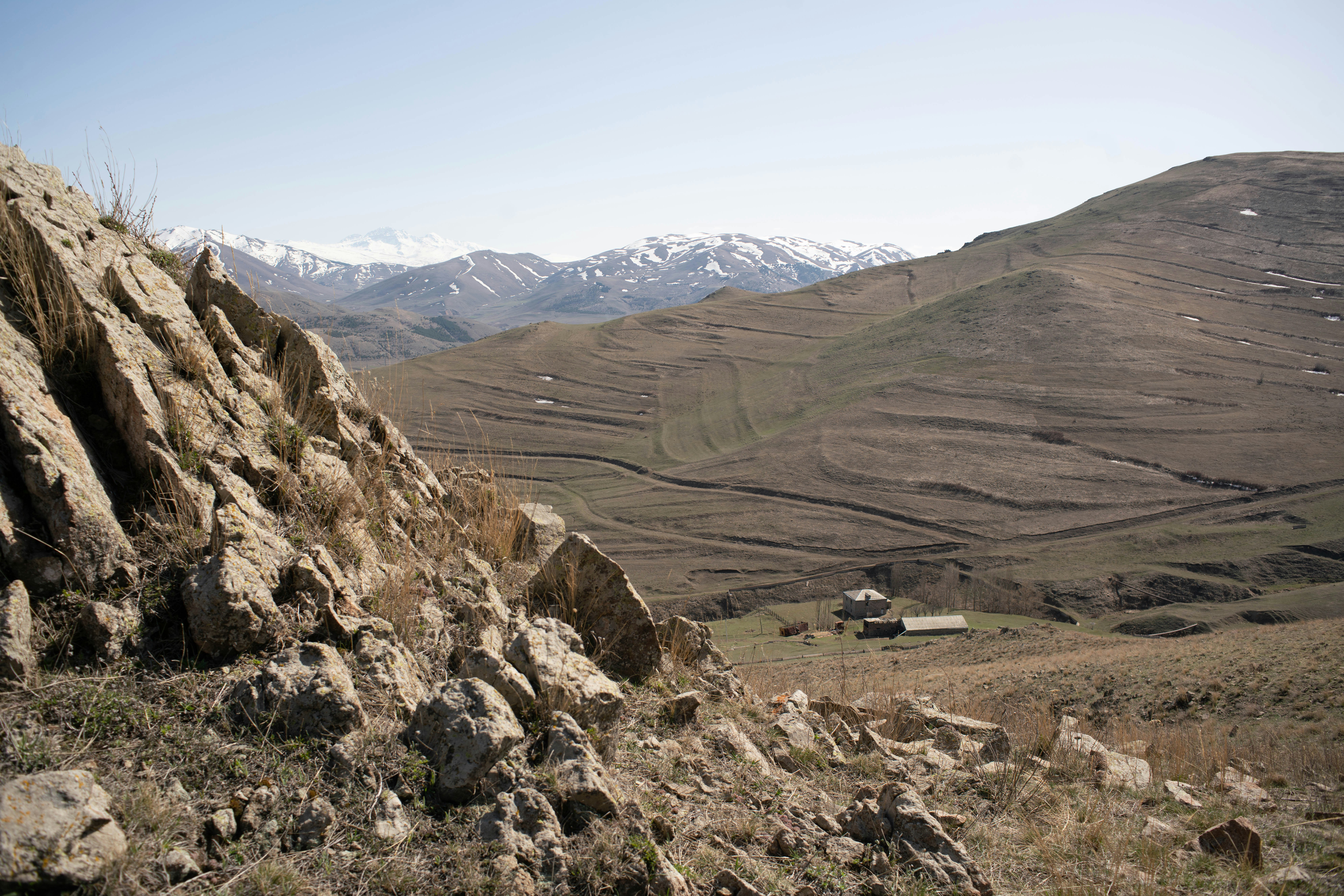 Lone Cabin Among Terraced Hills Beneath Snow-Dusted Peaks