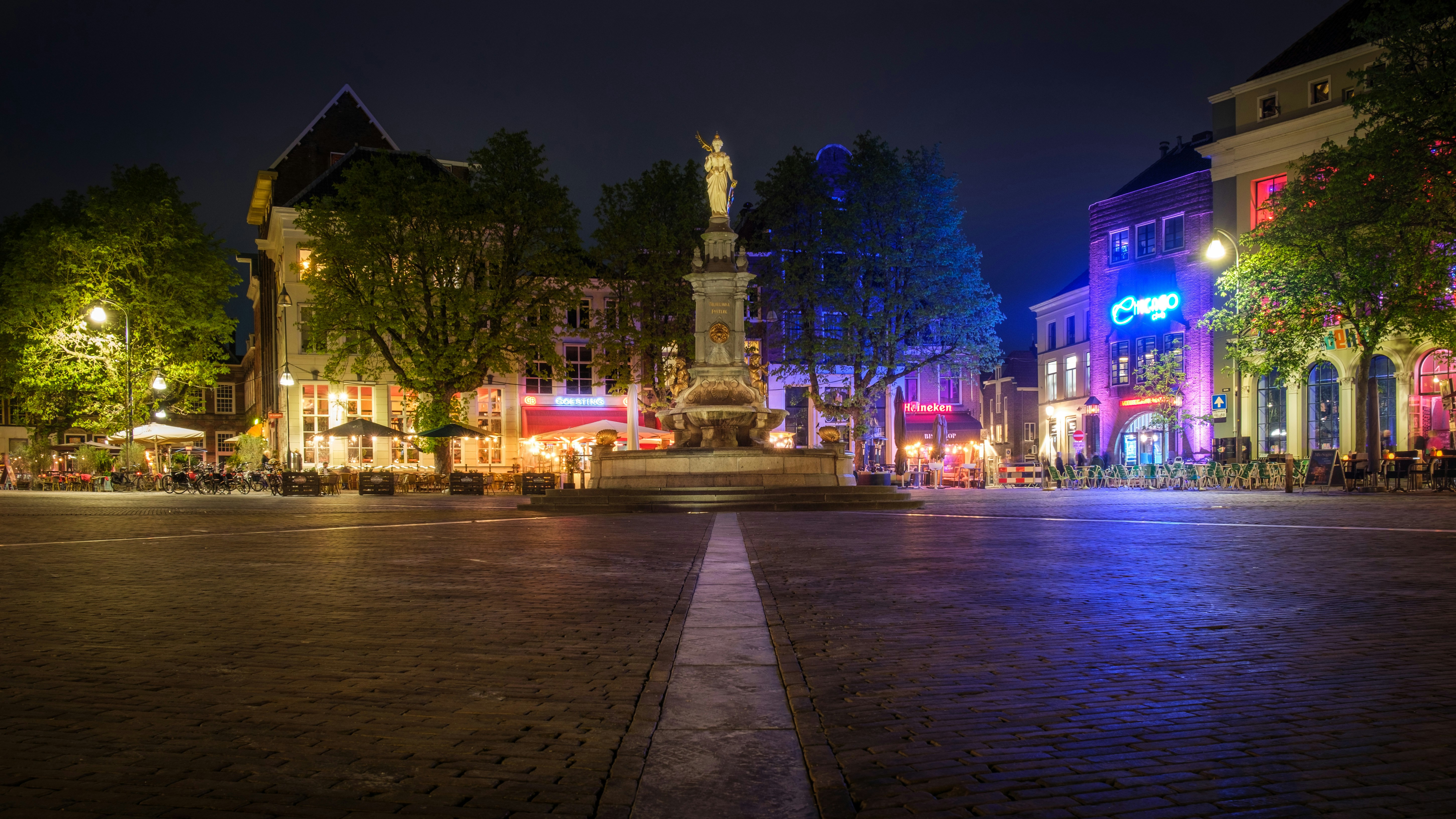 Una calle de la ciudad por la noche con edificios iluminados foto ...