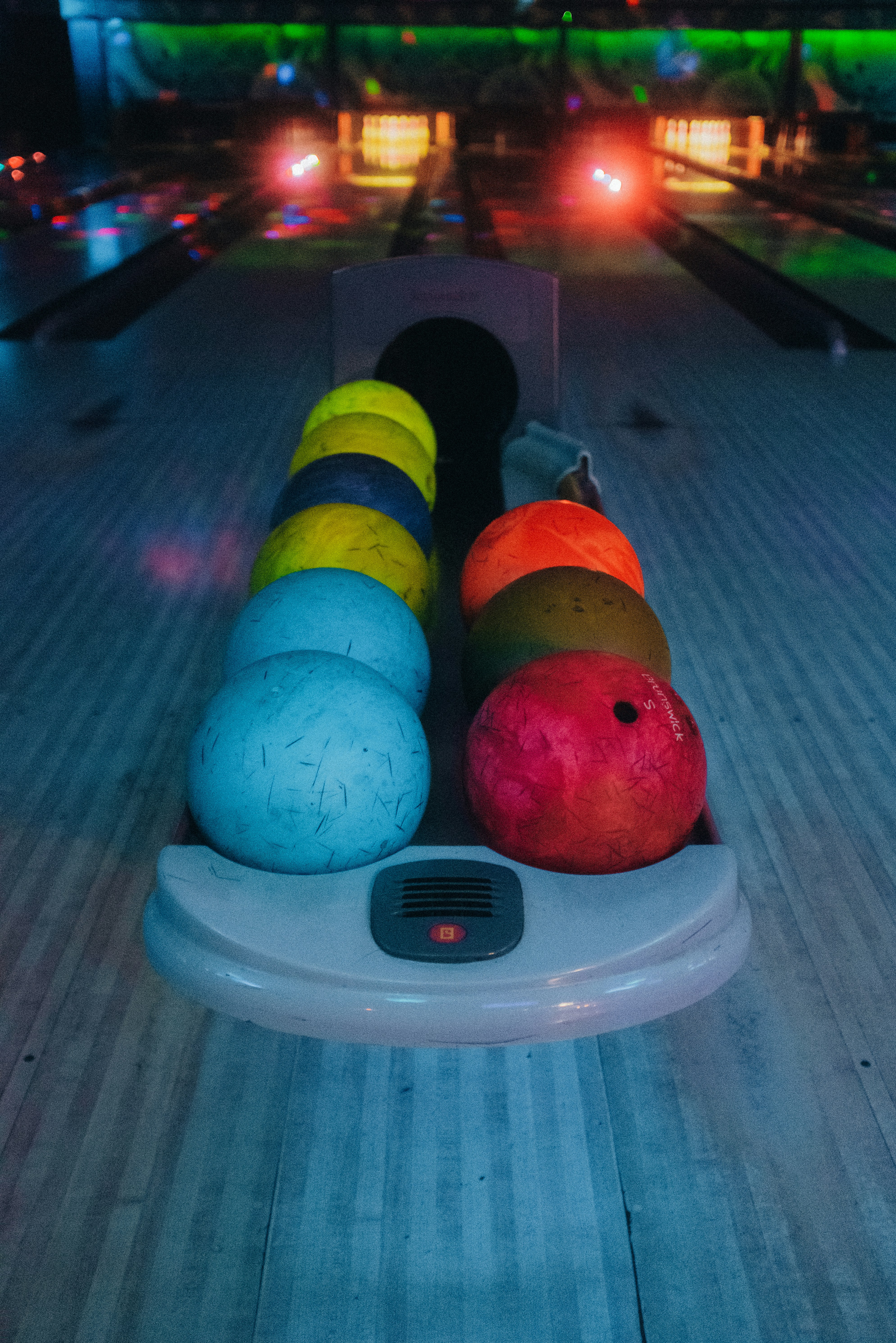 Chromatic Lane: A Row of Neon Bowling Balls Reaches Toward the Distant Pins