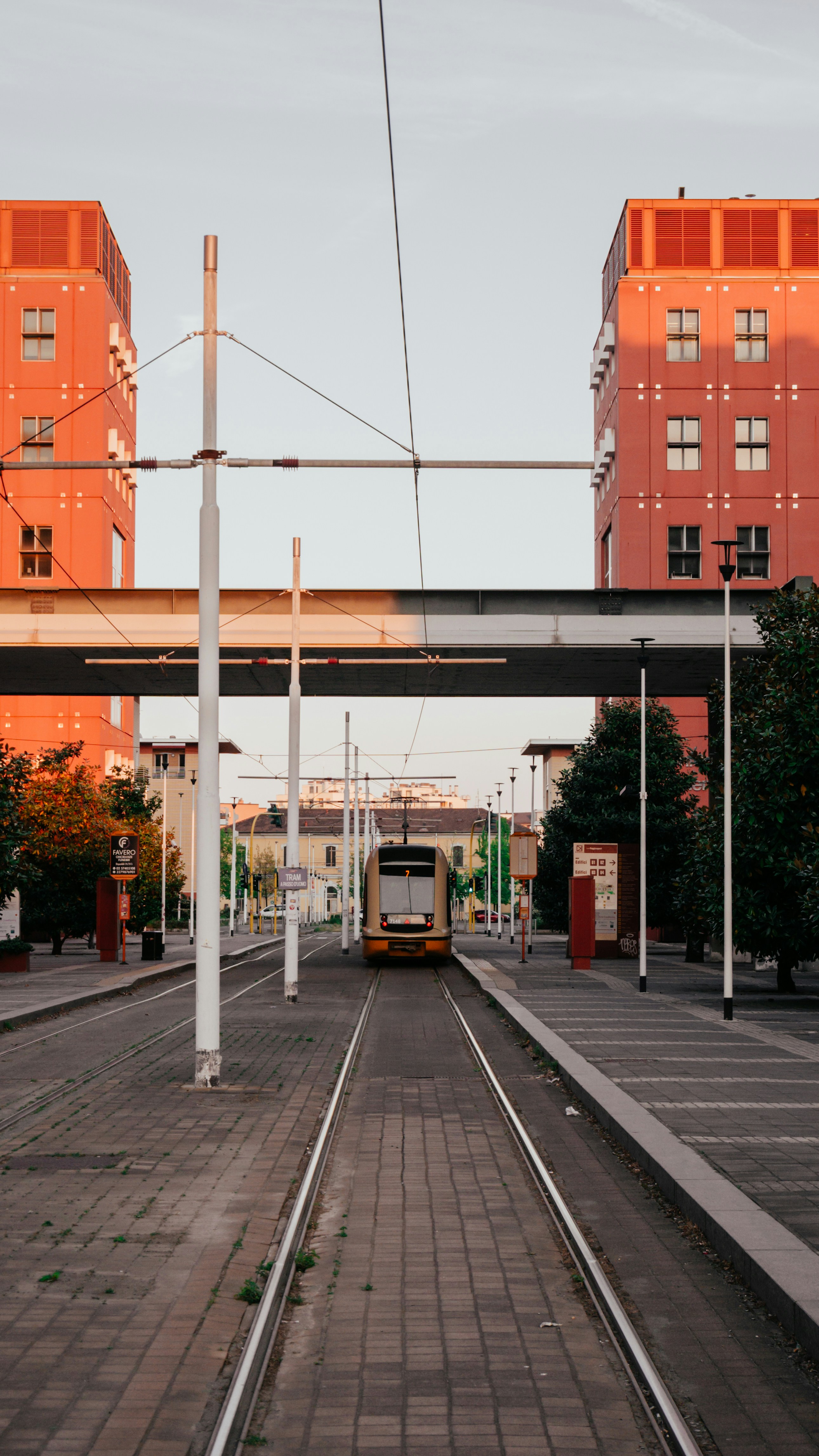 A train traveling down train tracks next to tall buildings photo – Free ...