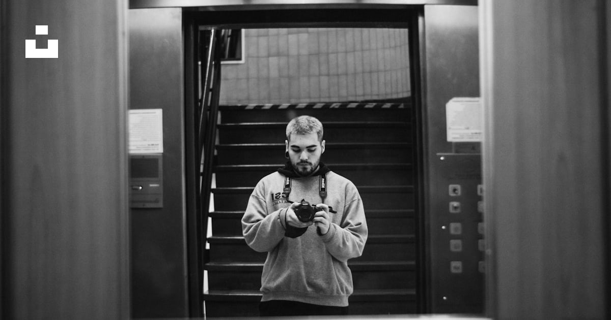 Foto Un Hombre Parado Frente A Un Espejo Mirando Su Teléfono Celular