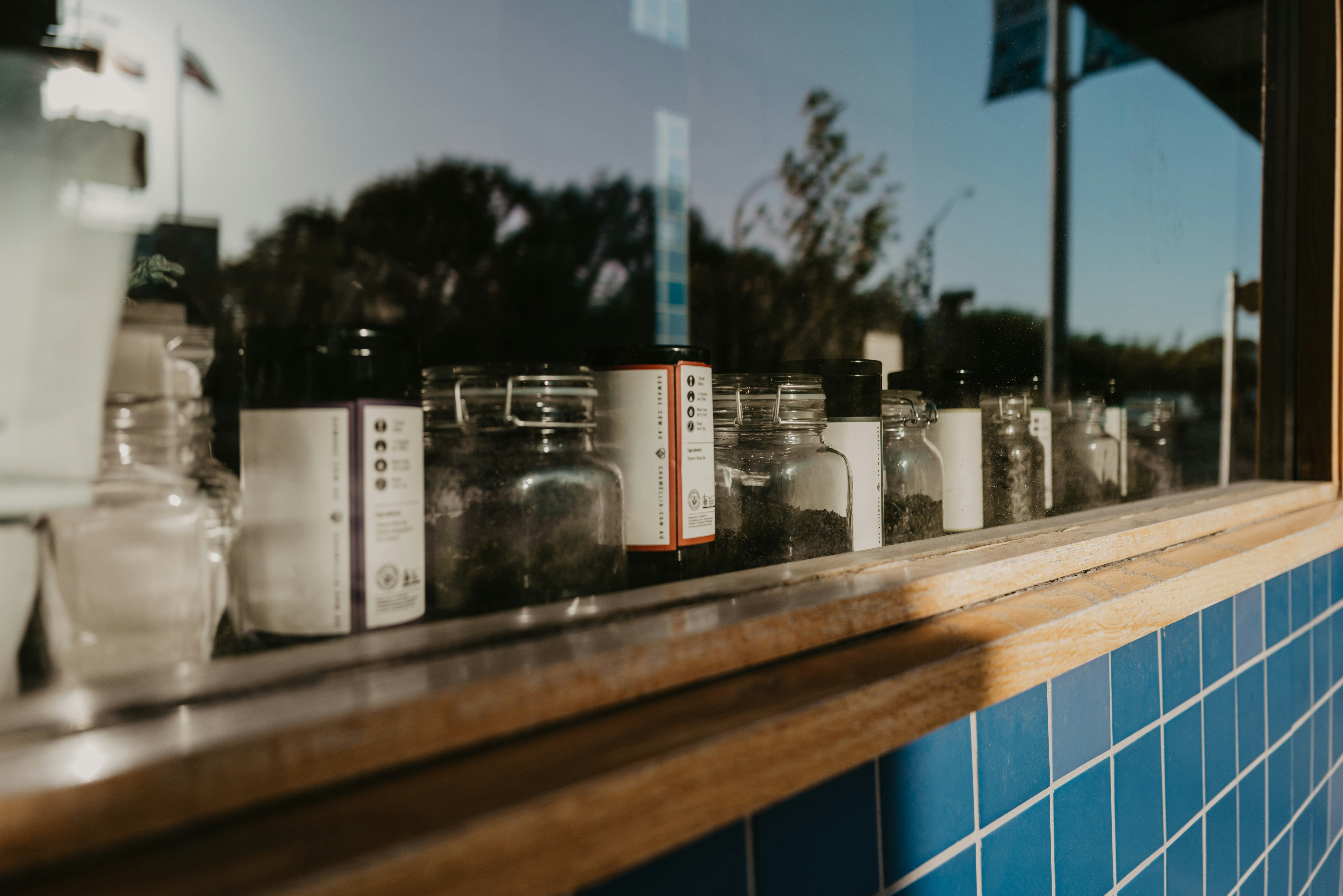 a row of jars sitting on top of a window sill