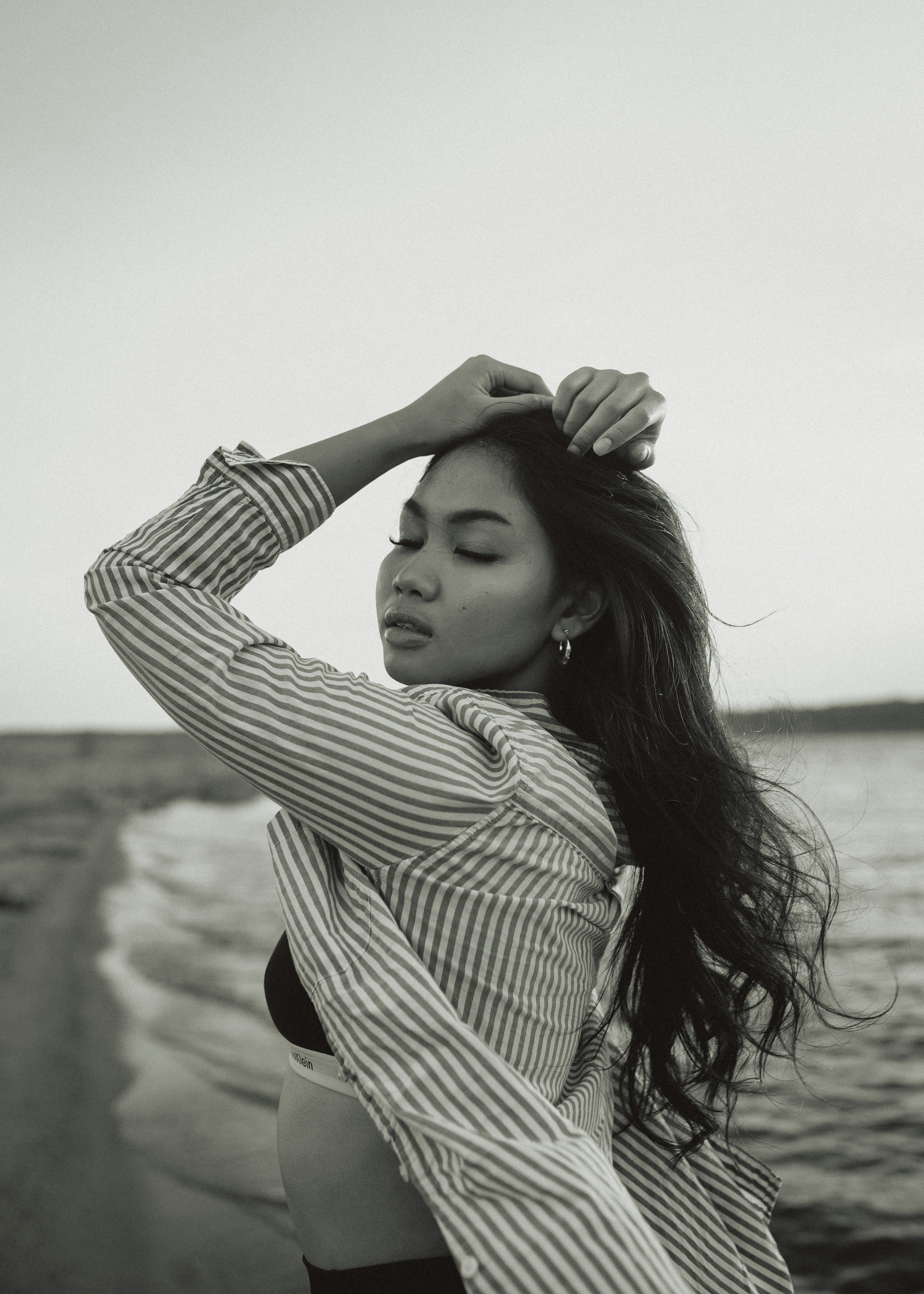 a woman standing on a beach next to the ocean