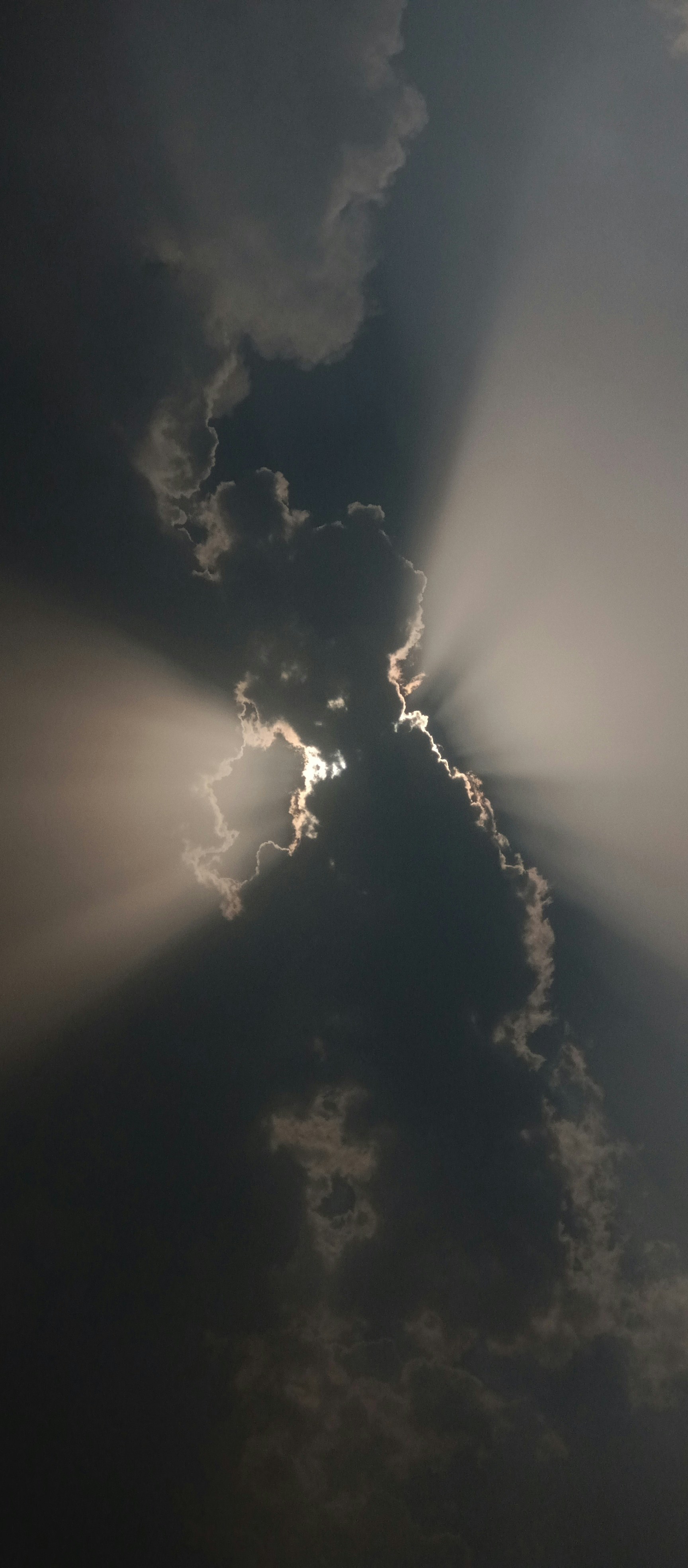 A stunning interplay of sunlight breaking through dark clouds creates a dramatic sky.