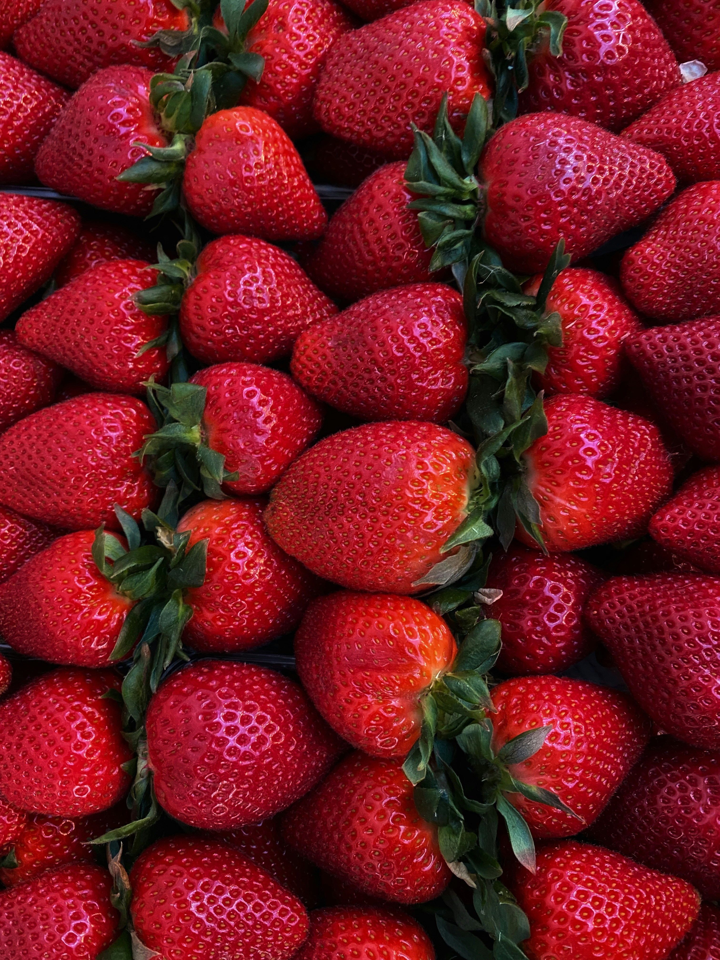 Foto zum Thema Ein Haufen roter Erdbeeren, die übereinander sitzen ...