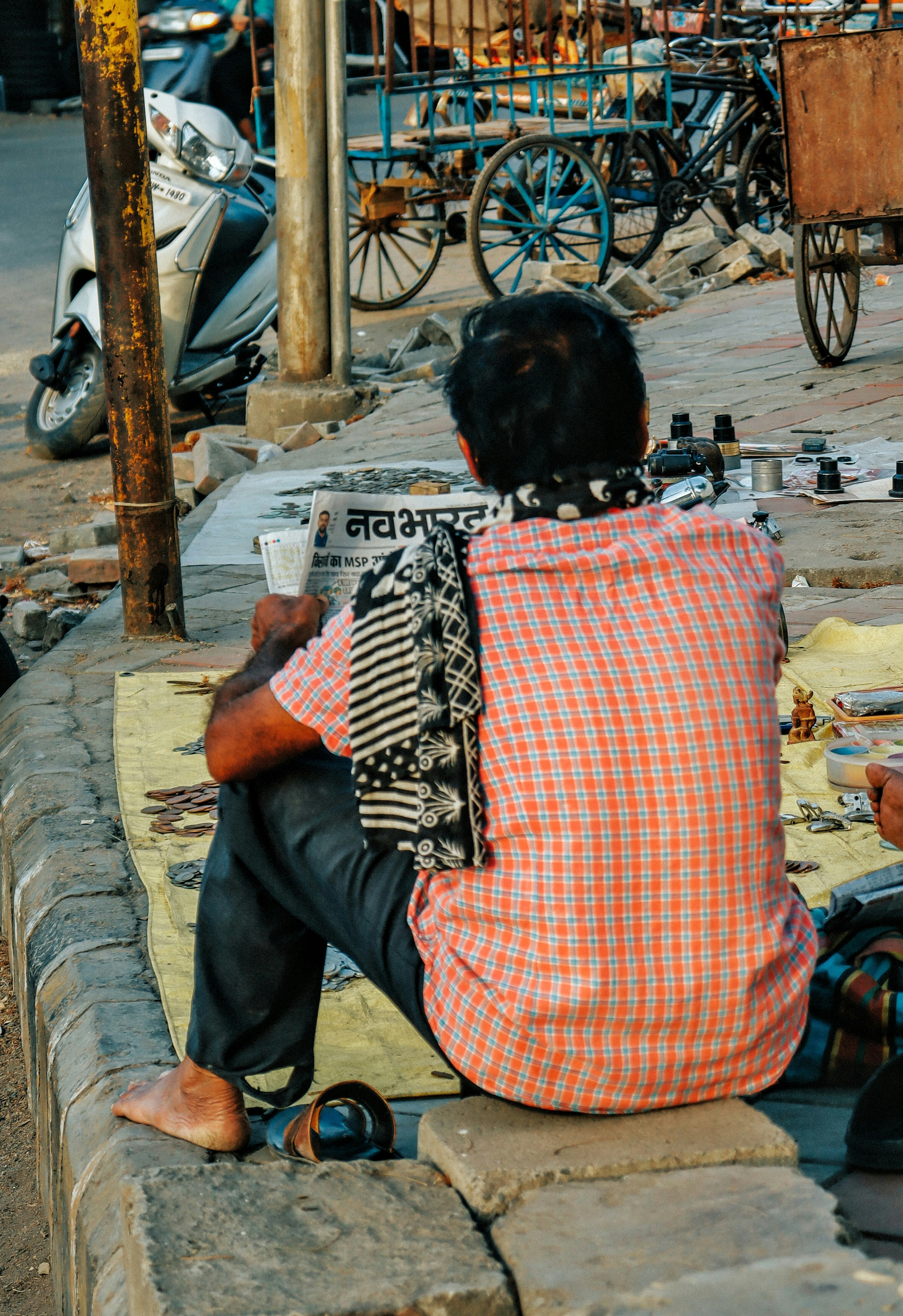 The Curbstone Reader: A Quiet Moment on a Market Street