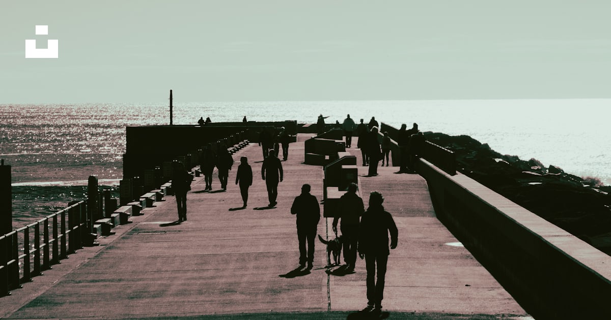 Foto Un Grupo De Personas Caminando Por Un Muelle Junto Al Océano