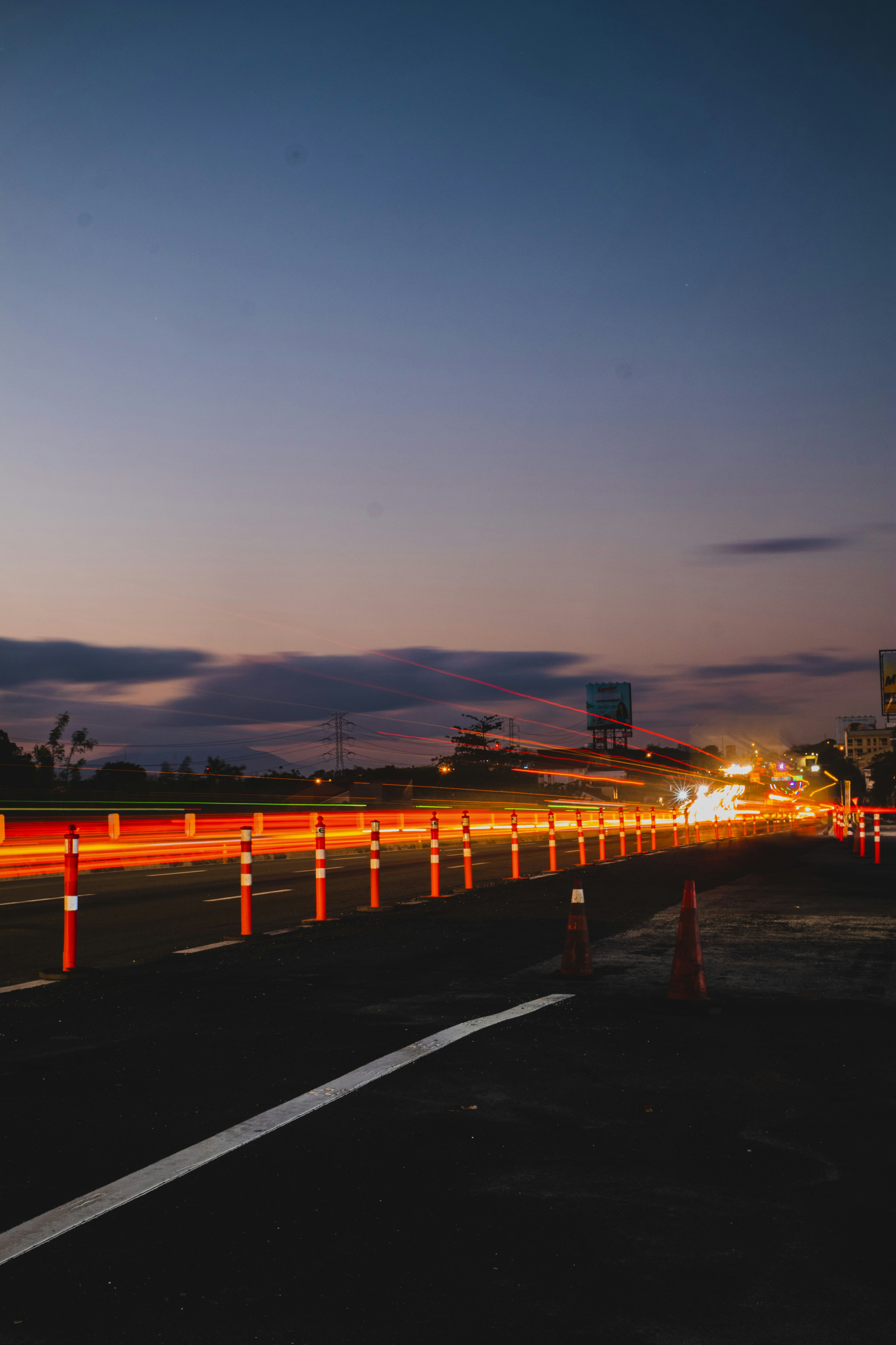 A long line of traffic cones on a highway photo – Free Road Image on ...