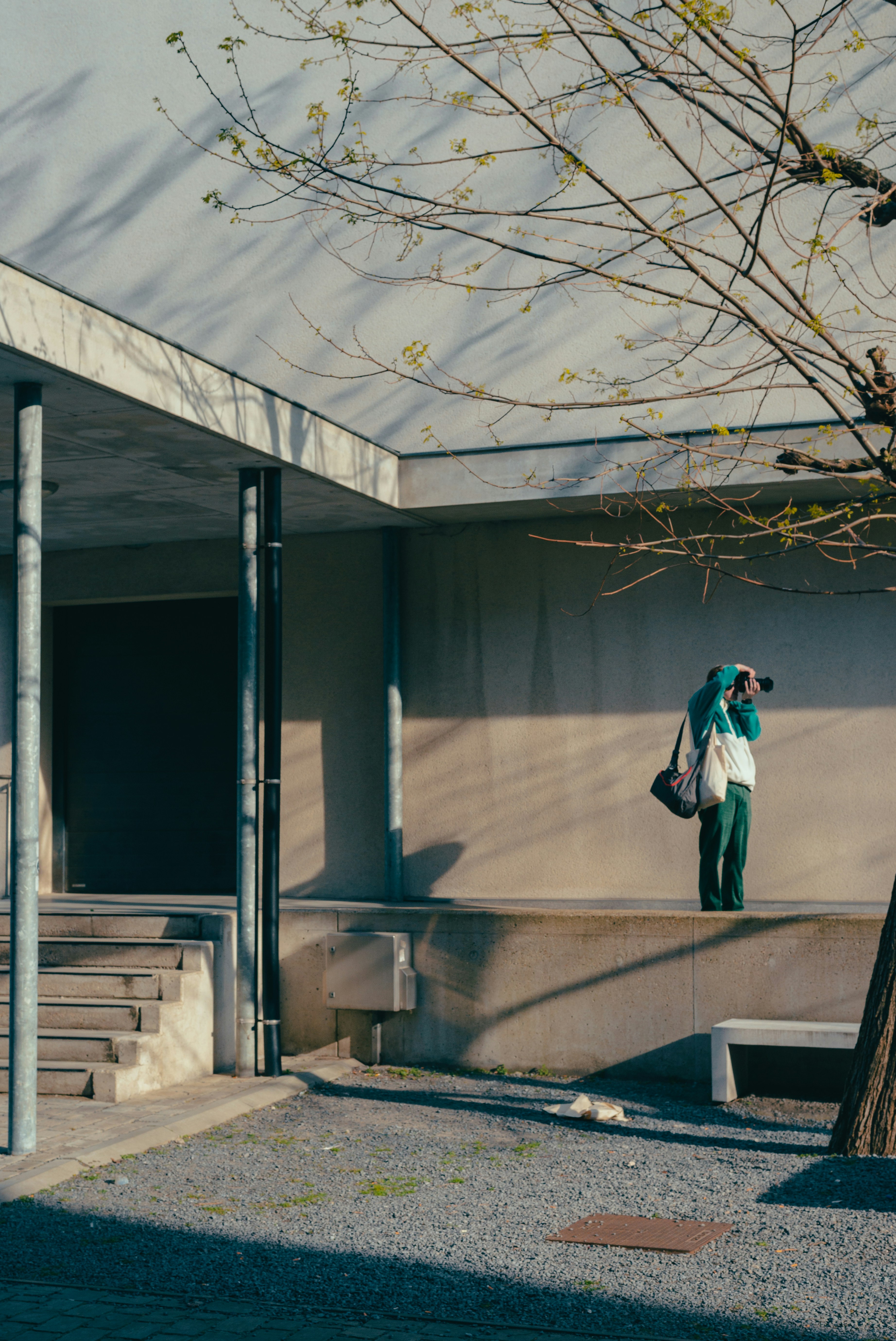 Teal-Clad Photographer on a Quiet Rooftop Terrace