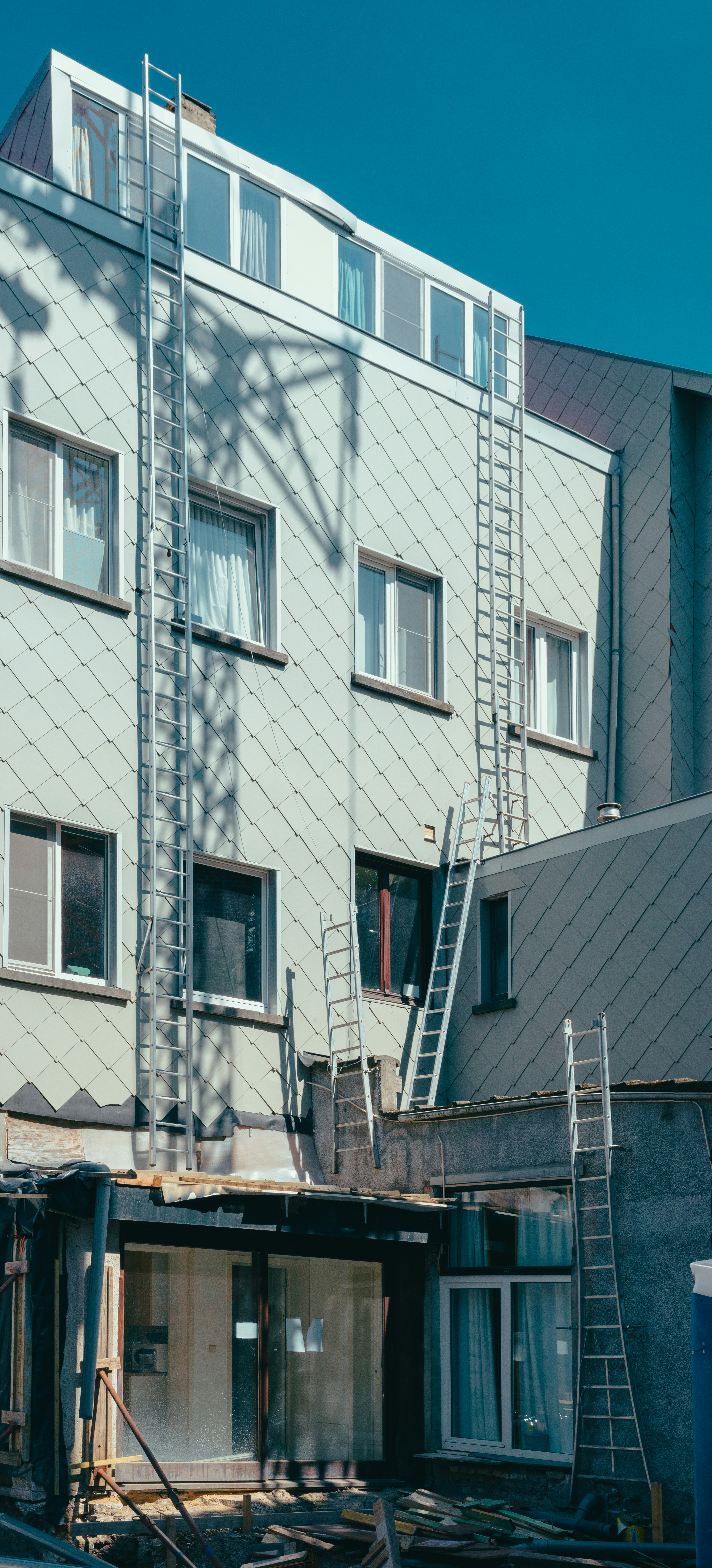 A tall building with a ladder on the side of it photo – Free Ghent ...