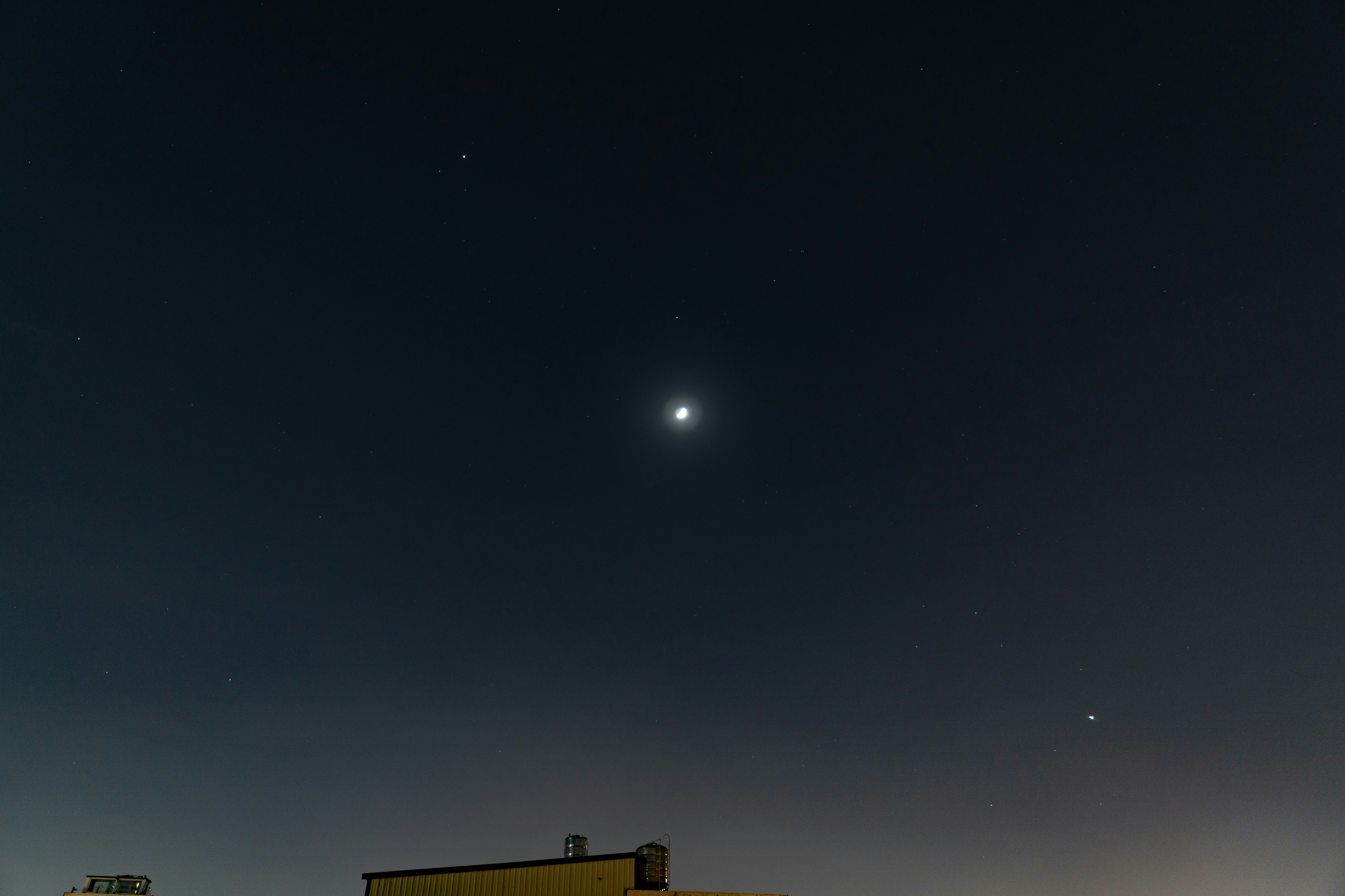 Moon Over the Quiet Rooftops: A Night Sky's Celestial Spotlight