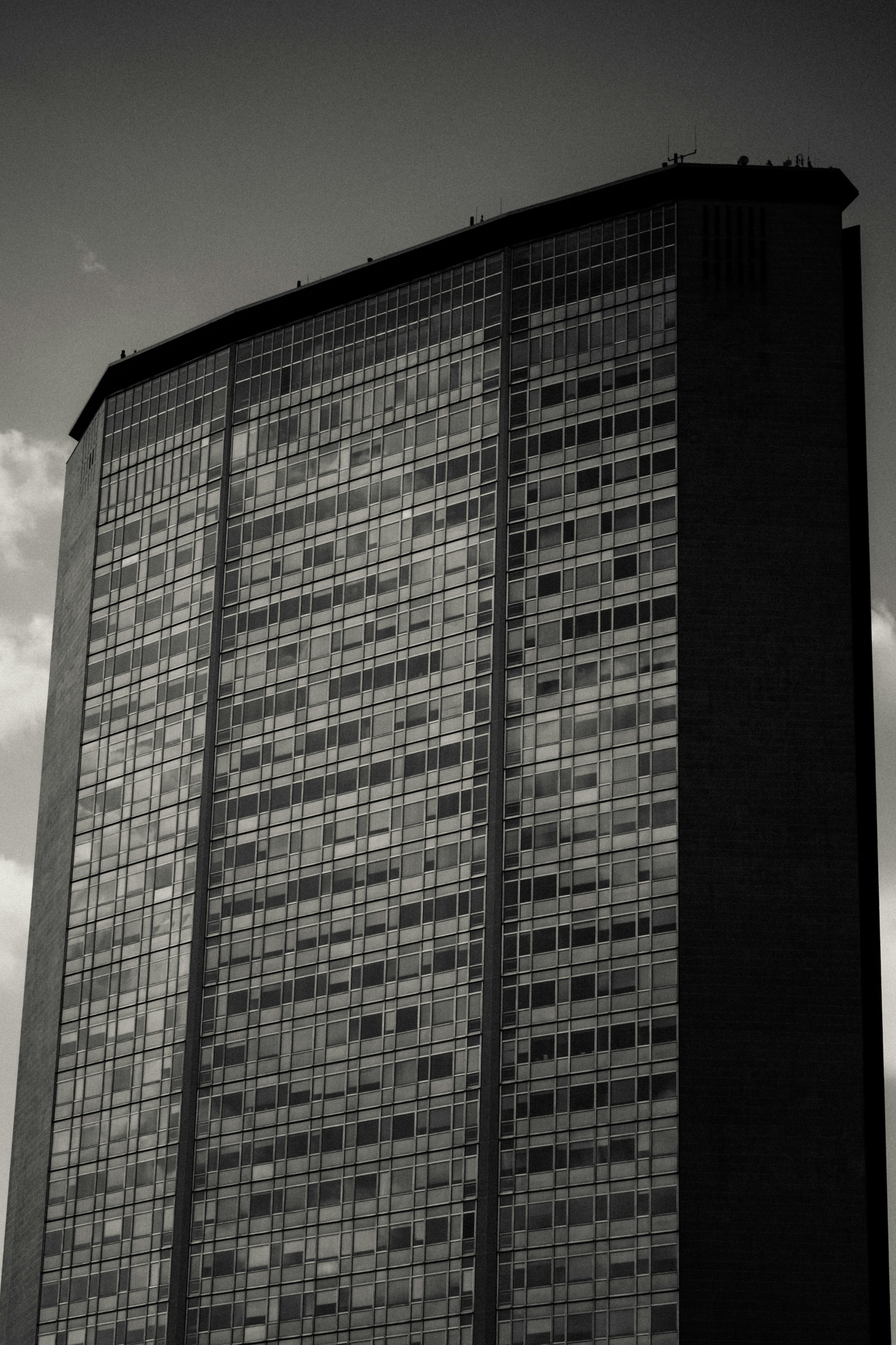 Gridded Monolith: A Tall Facade Rising Against the Sky