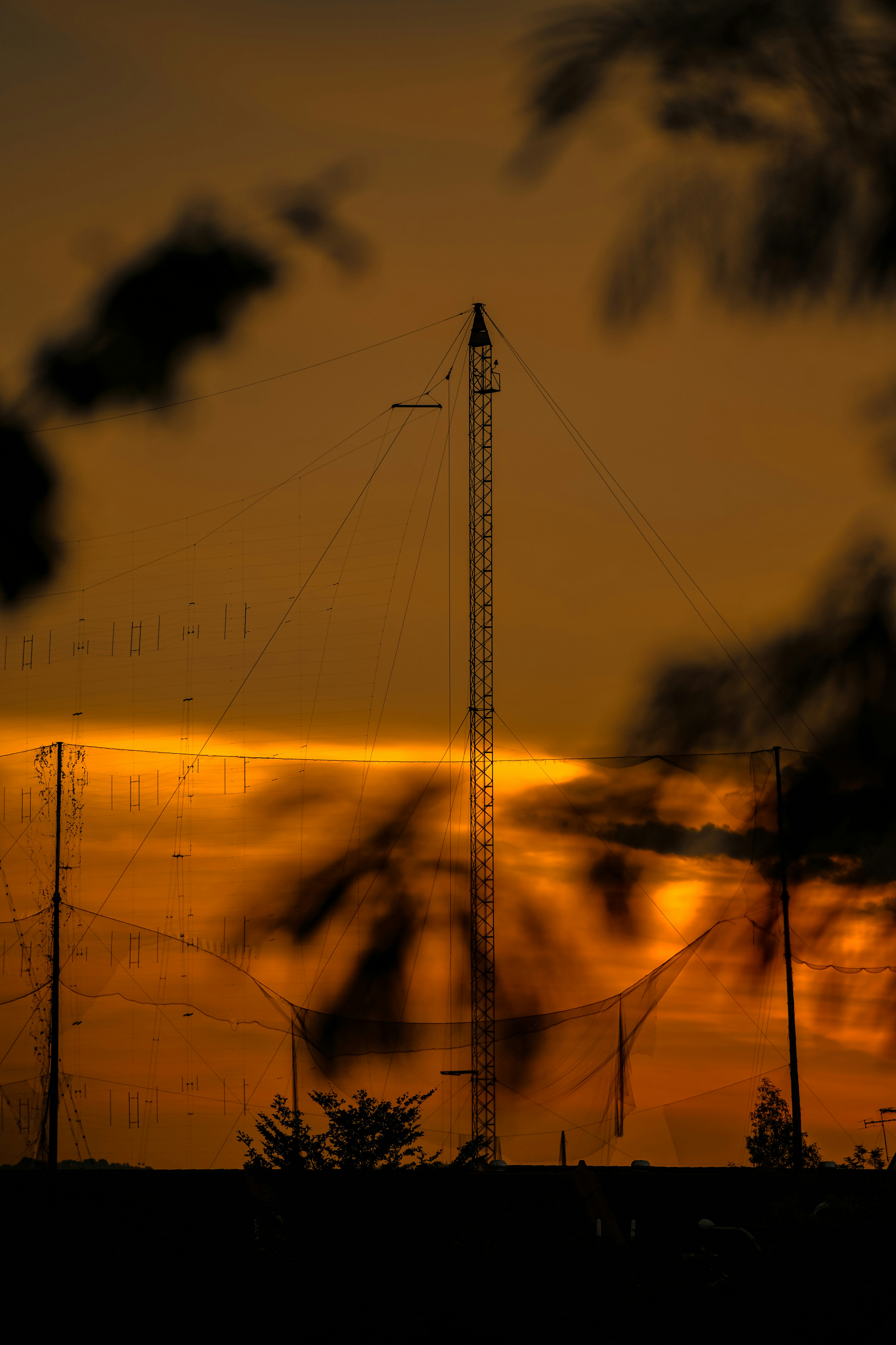 the sun is setting behind a radio tower