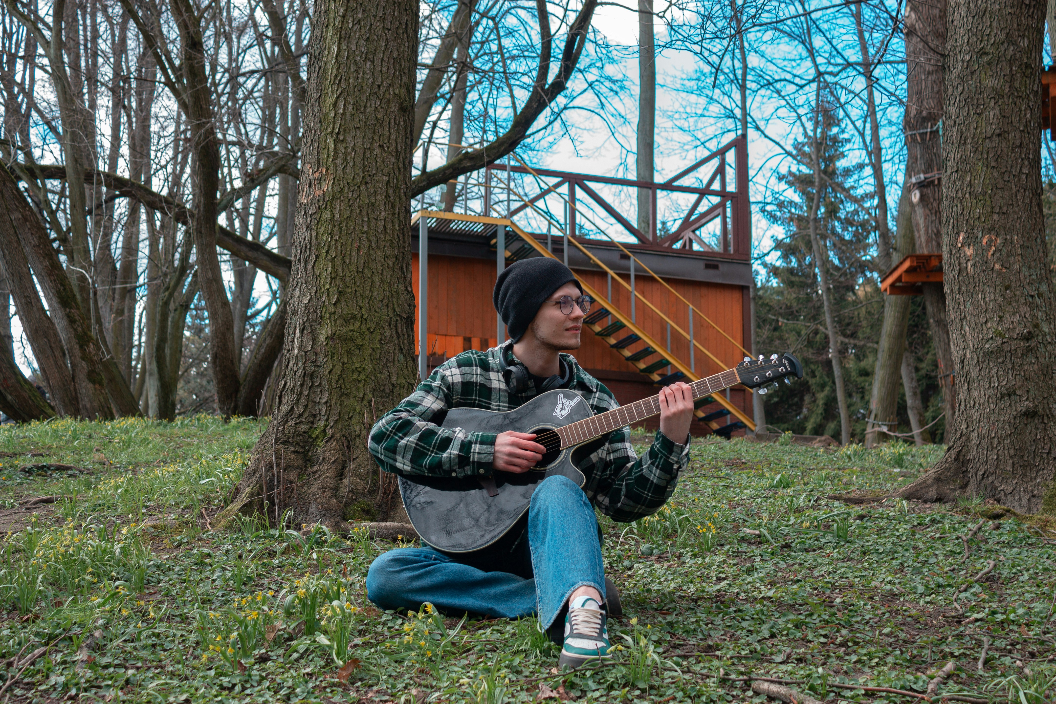 a man sitting on the ground playing a guitar