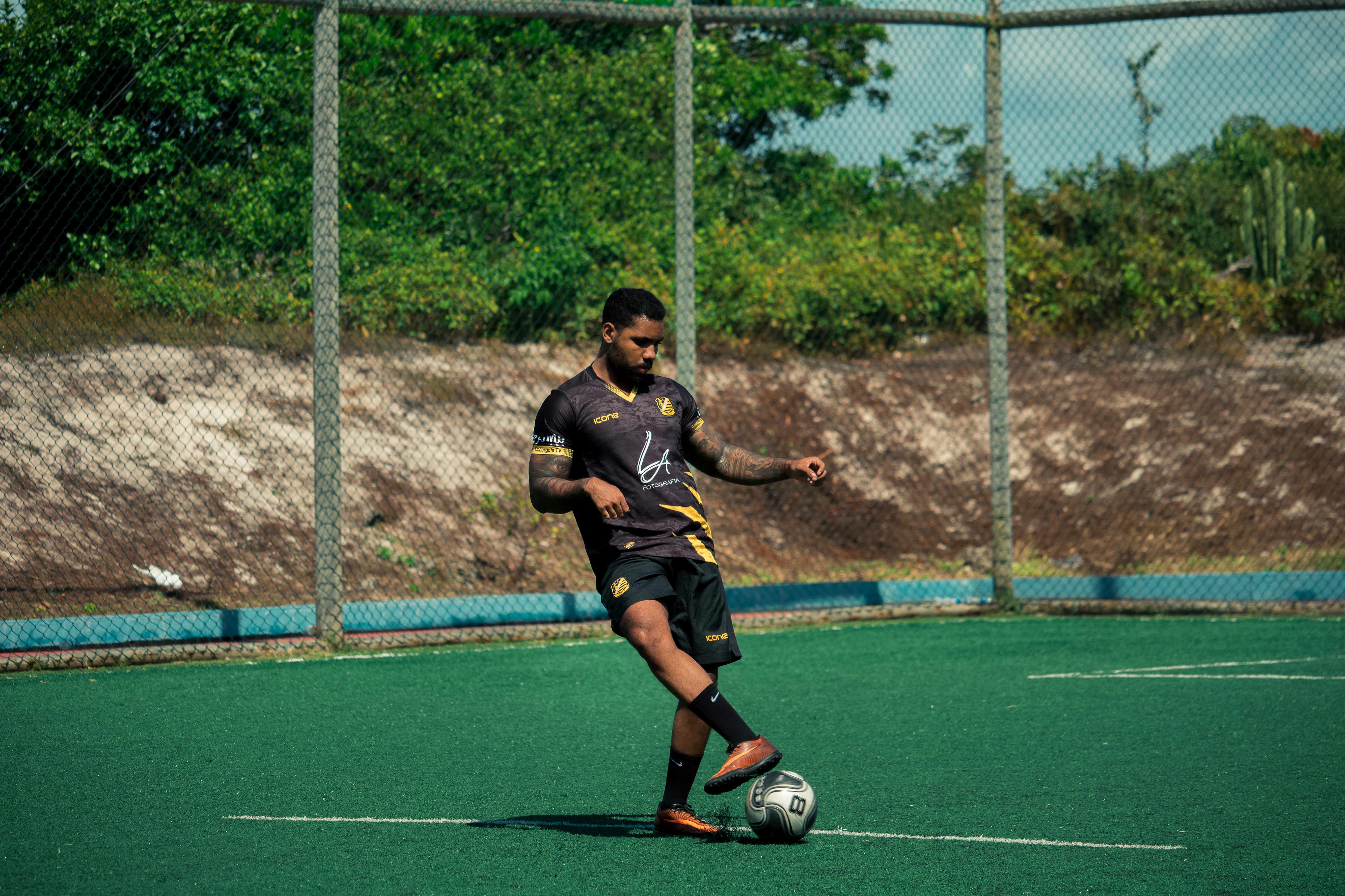 Foto Un hombre pateando una pelota de fútbol en un campo – Imagen ...