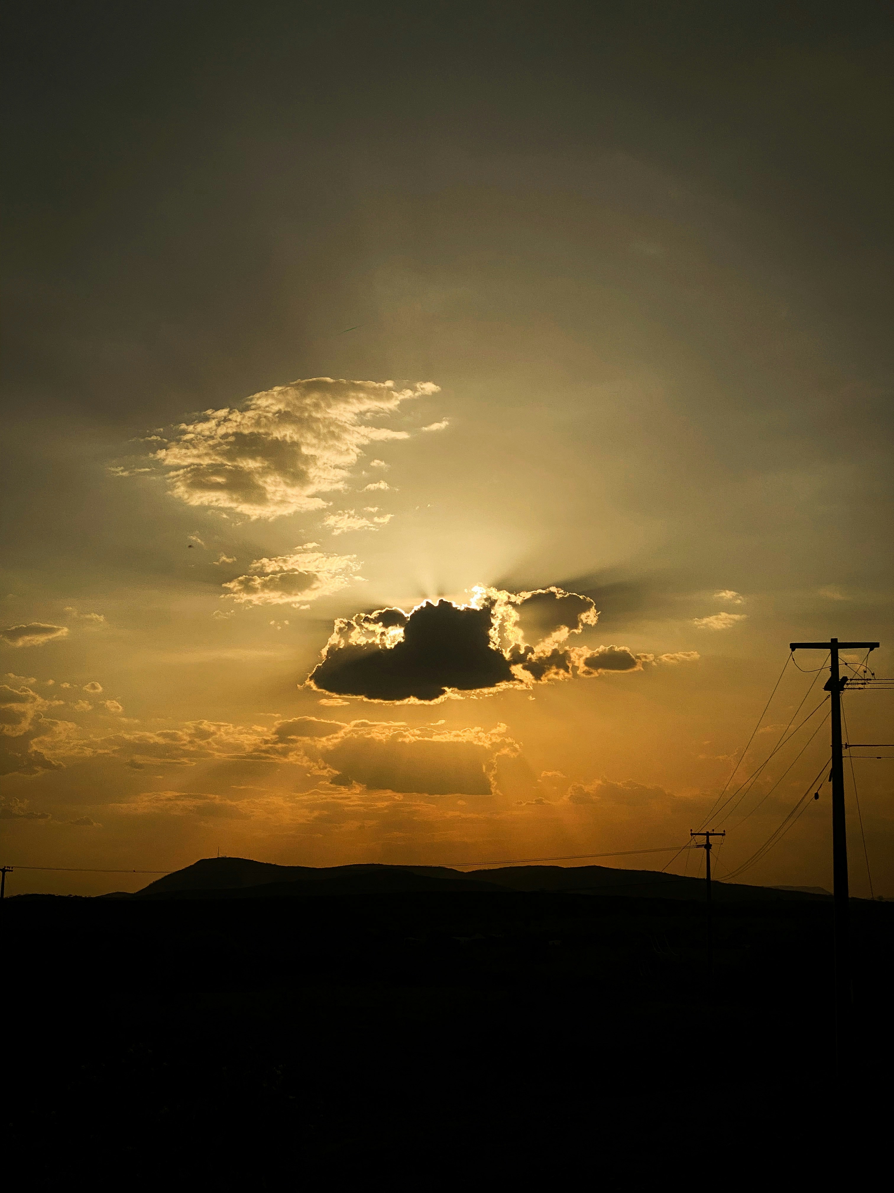 Sunburst Halo Behind a Lone Cloud Over a Quiet Plain