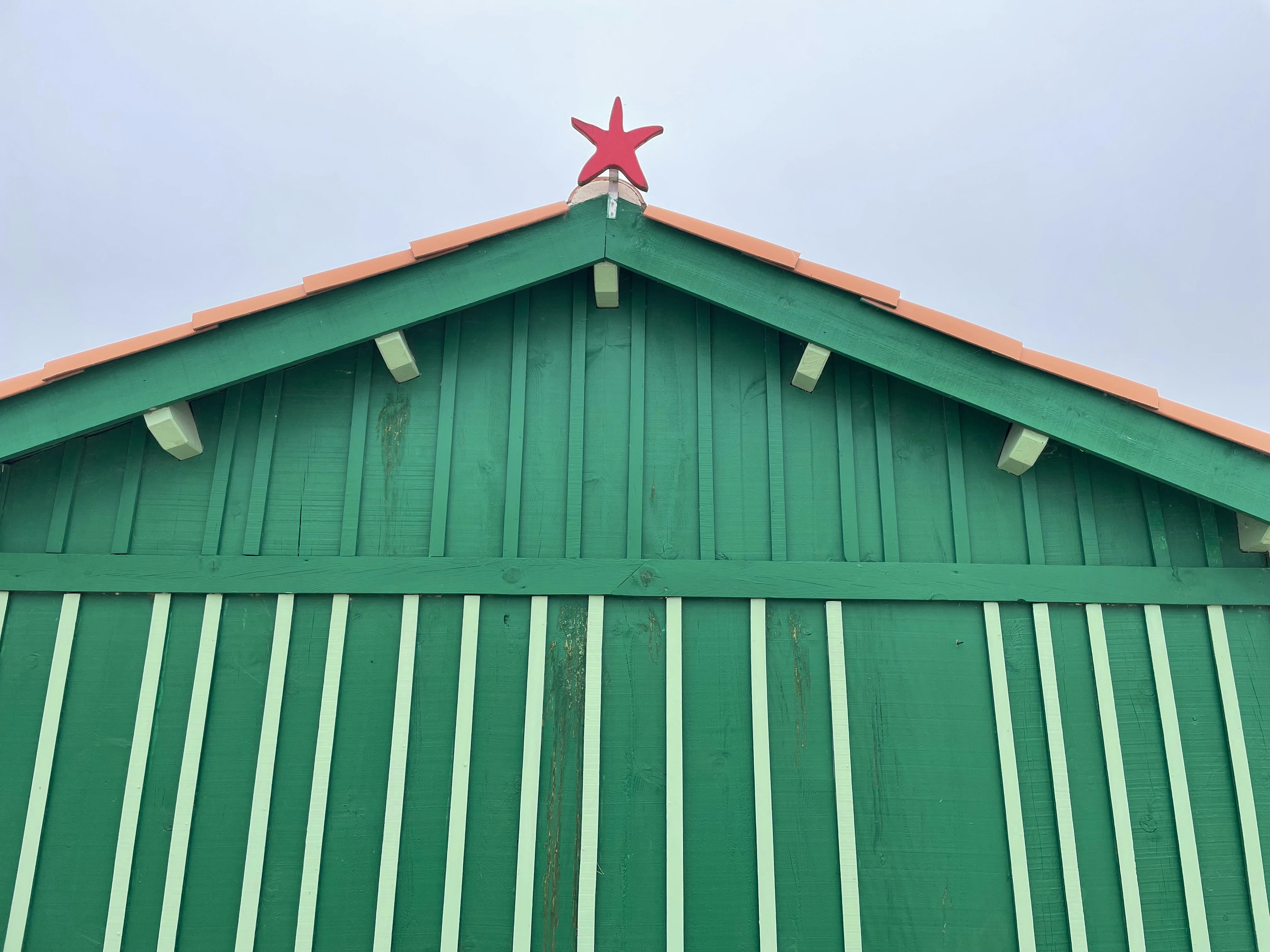 Star atop a green gable: minimal architectural geometry