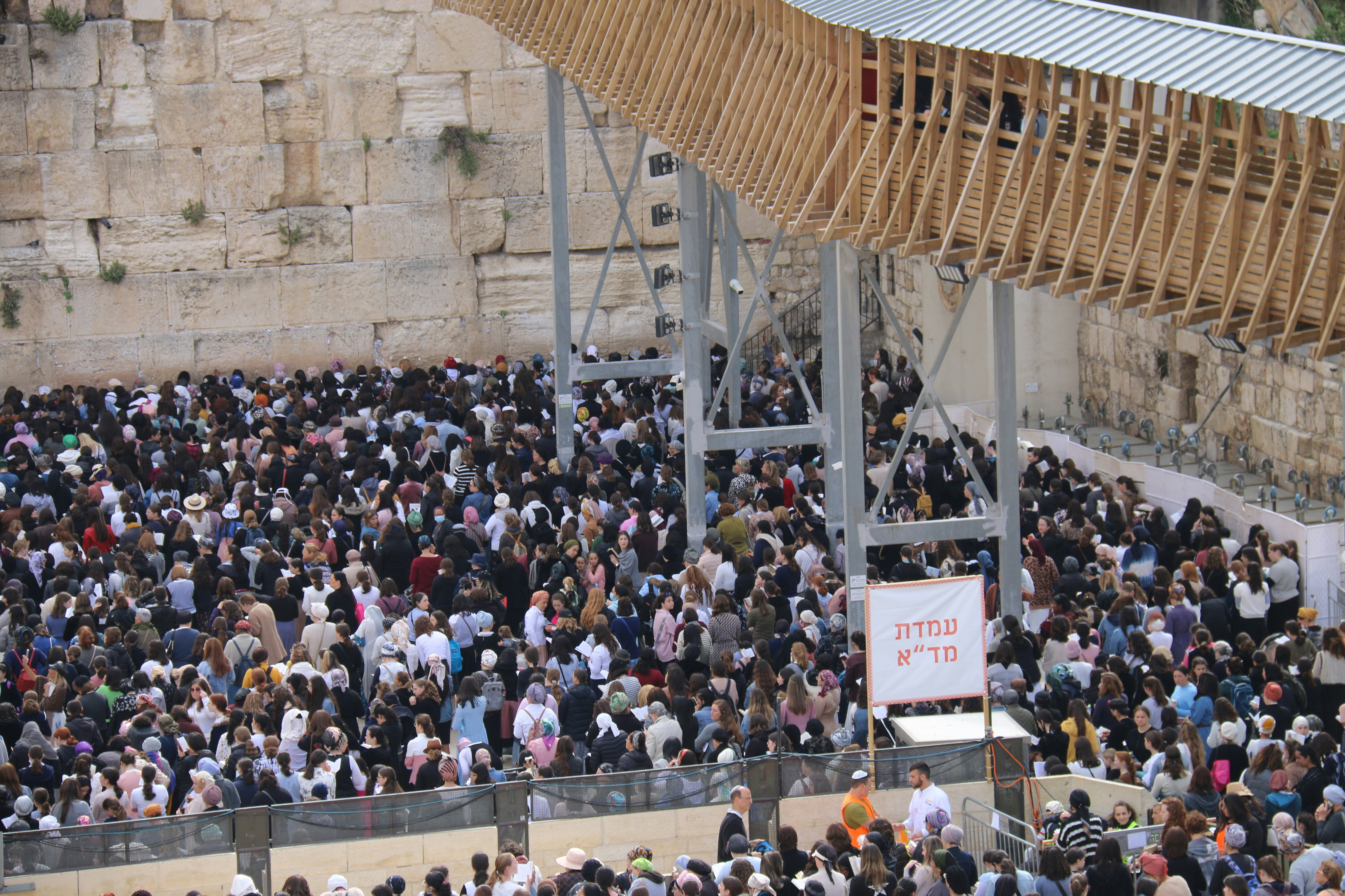 A crowd of people standing around a wooden structure photo – Free Grey ...