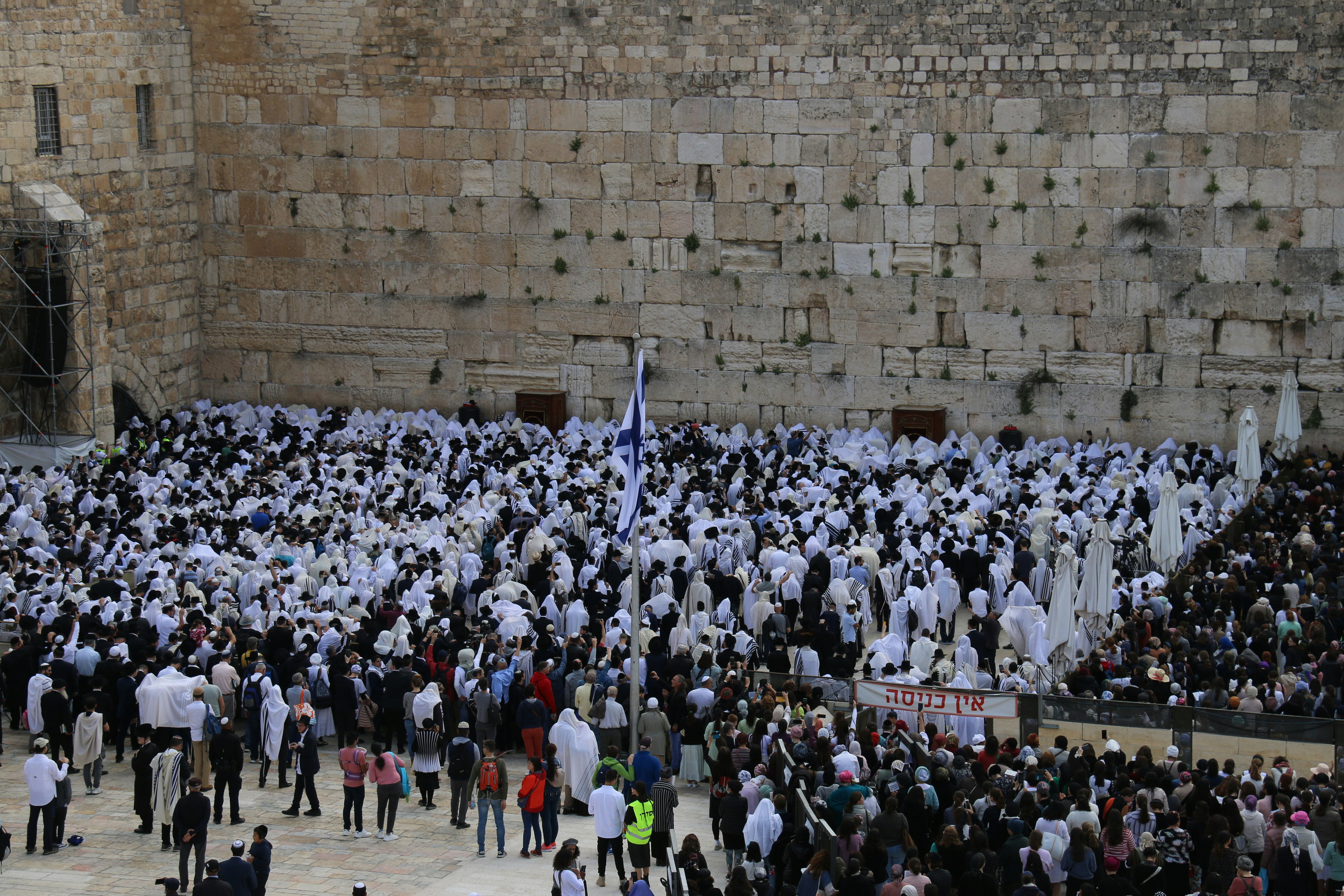 A crowd of people standing around a stone wall photo – Free Person ...