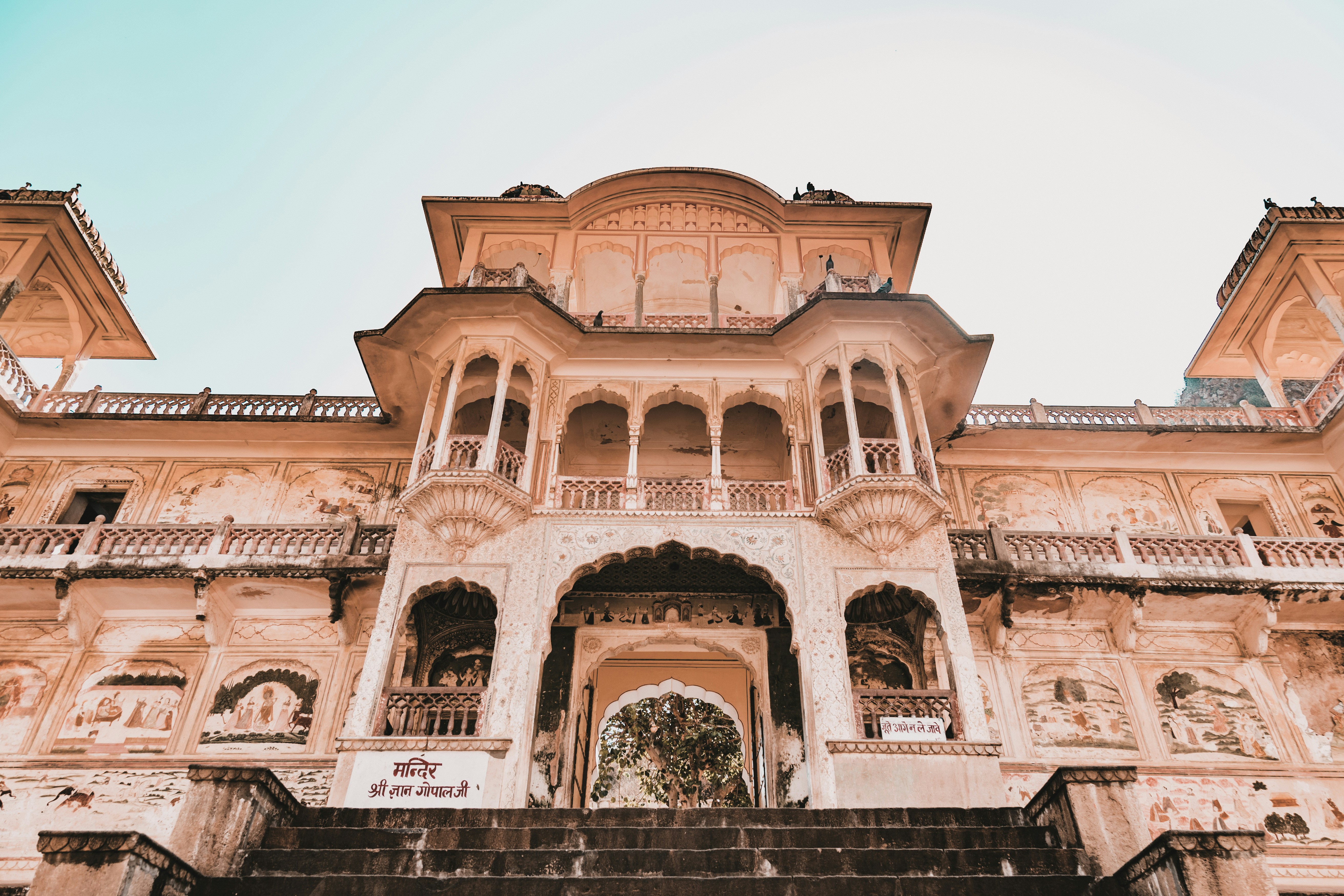 Intricate architecture of a weathered palace, showcasing ornate balconies and detailed carvings. The scene captures the essence of historical grandeur.