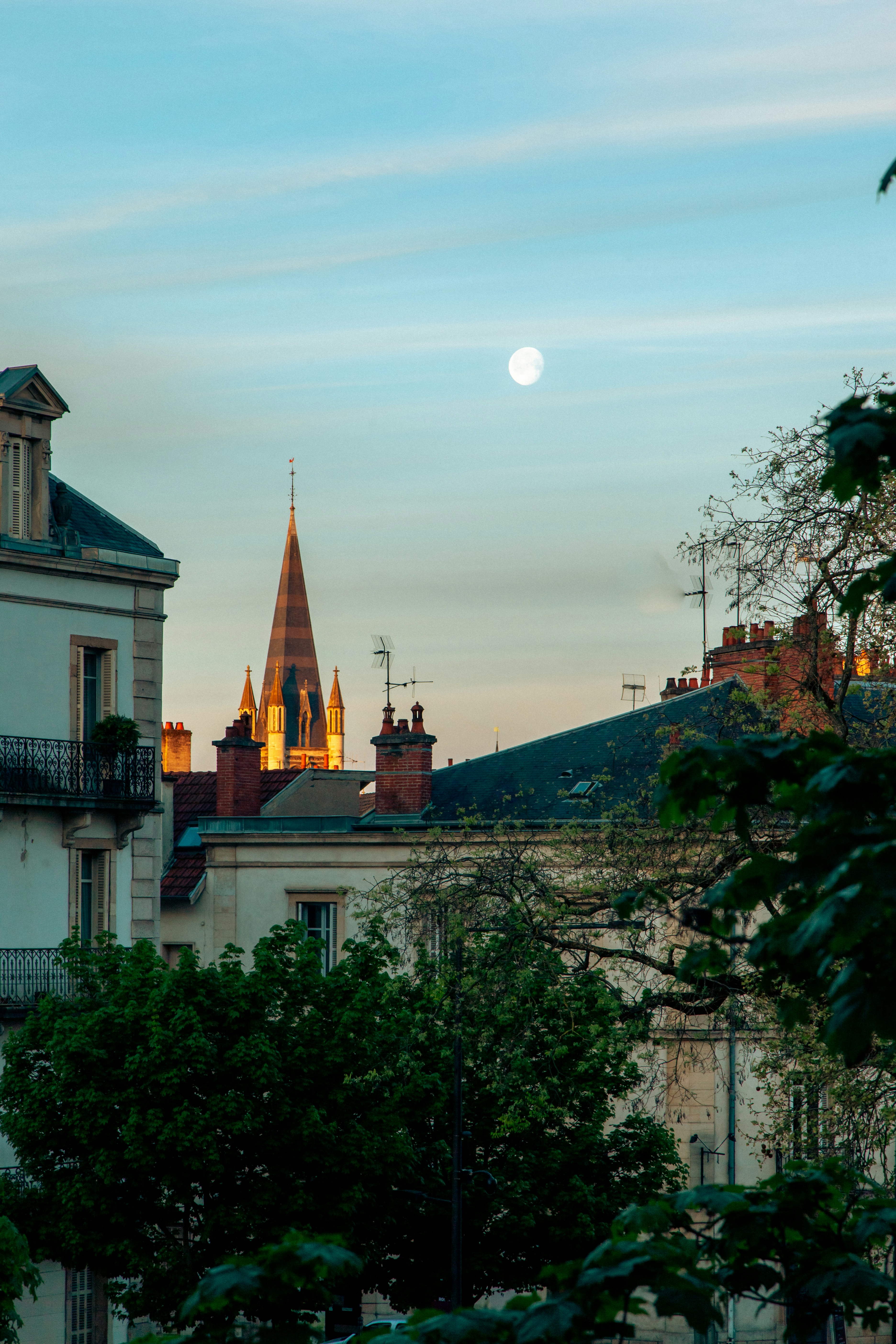 Moon Over a Parisian Rooftop Spire at Golden Hour