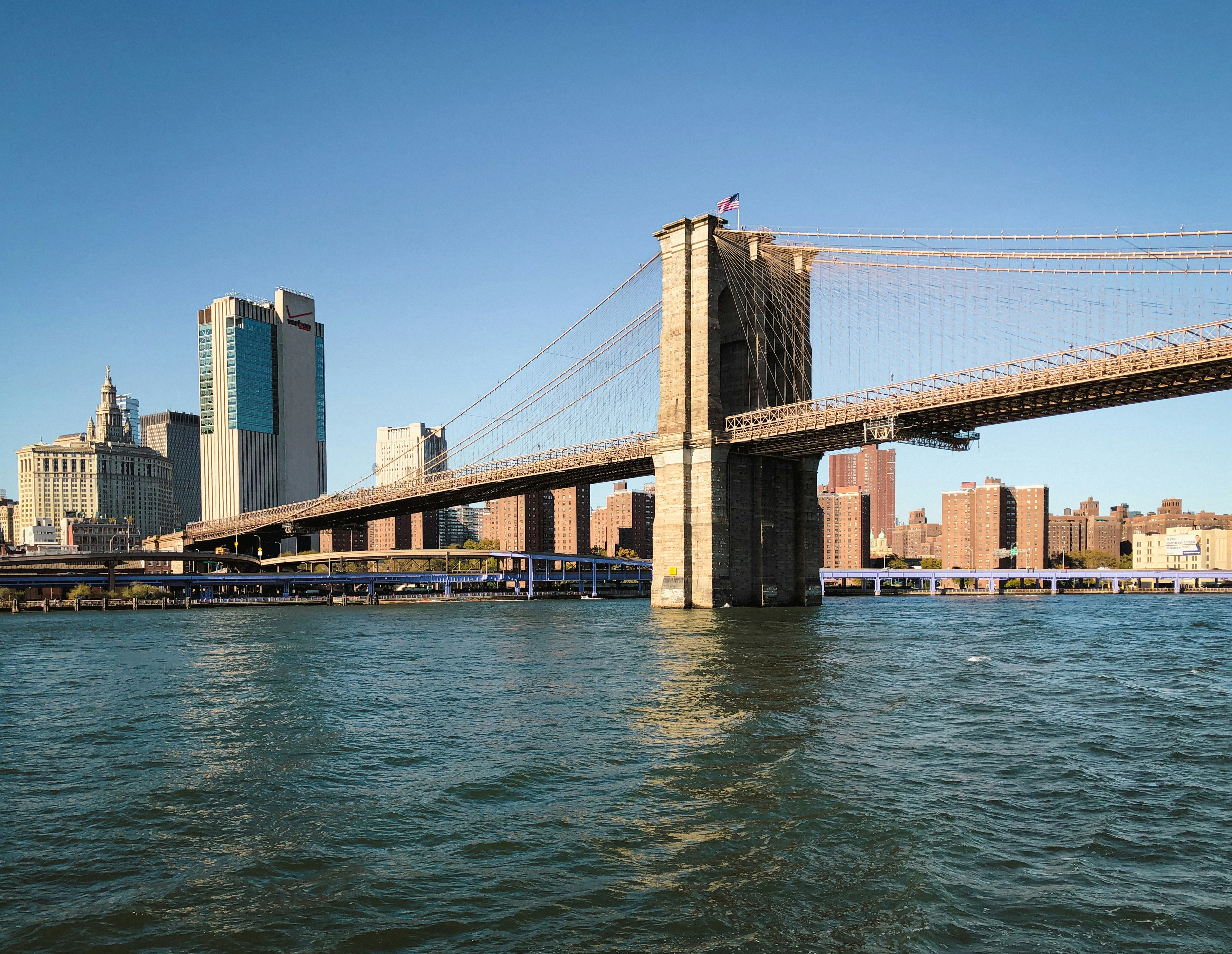 Brooklyn Bridge connecting Manhattan and Brooklyn, showcasing the urban skyline and the vibrant waters below.