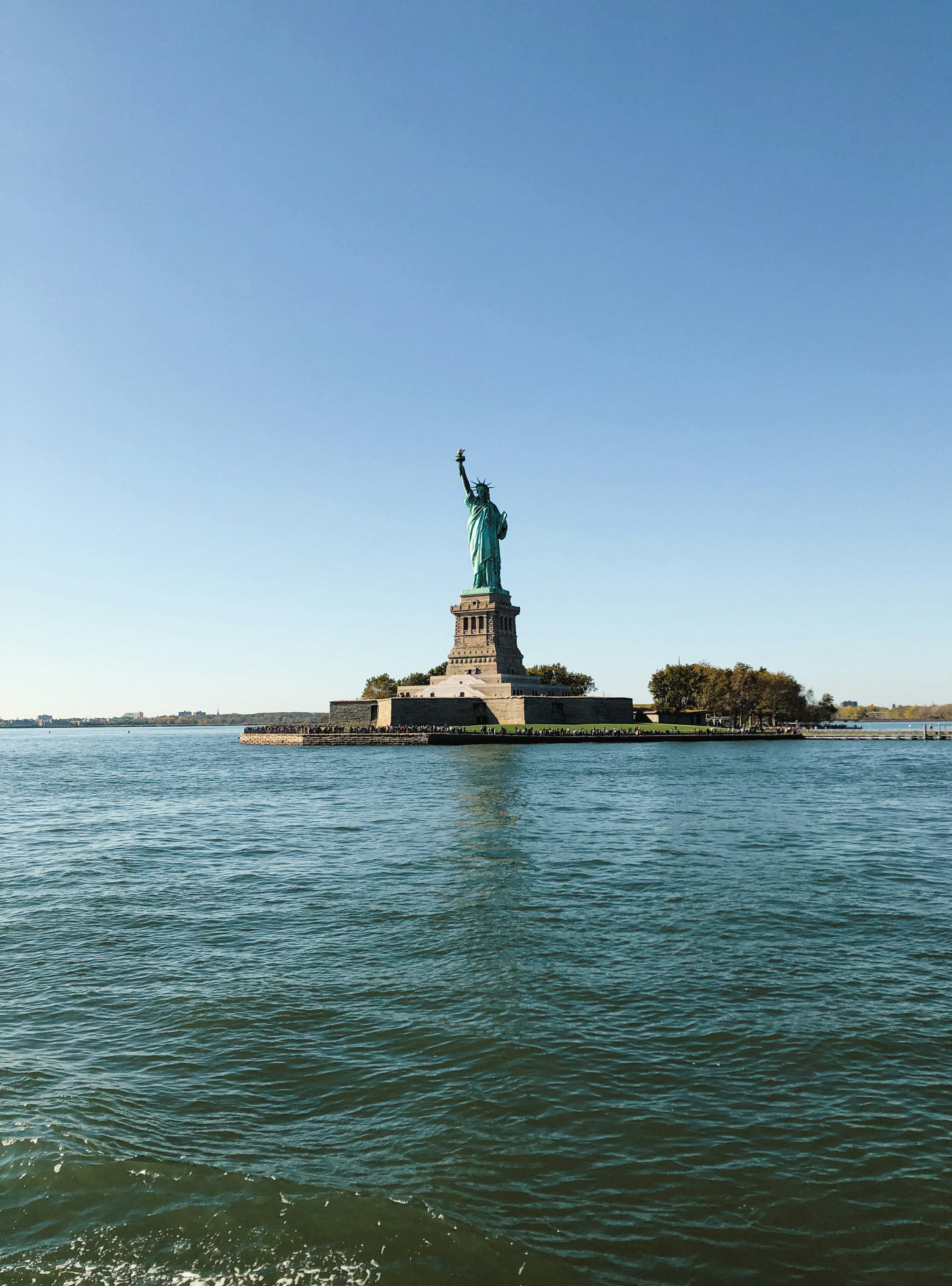 Liberty on the Horizon: Statue Island Across Quiet Waters