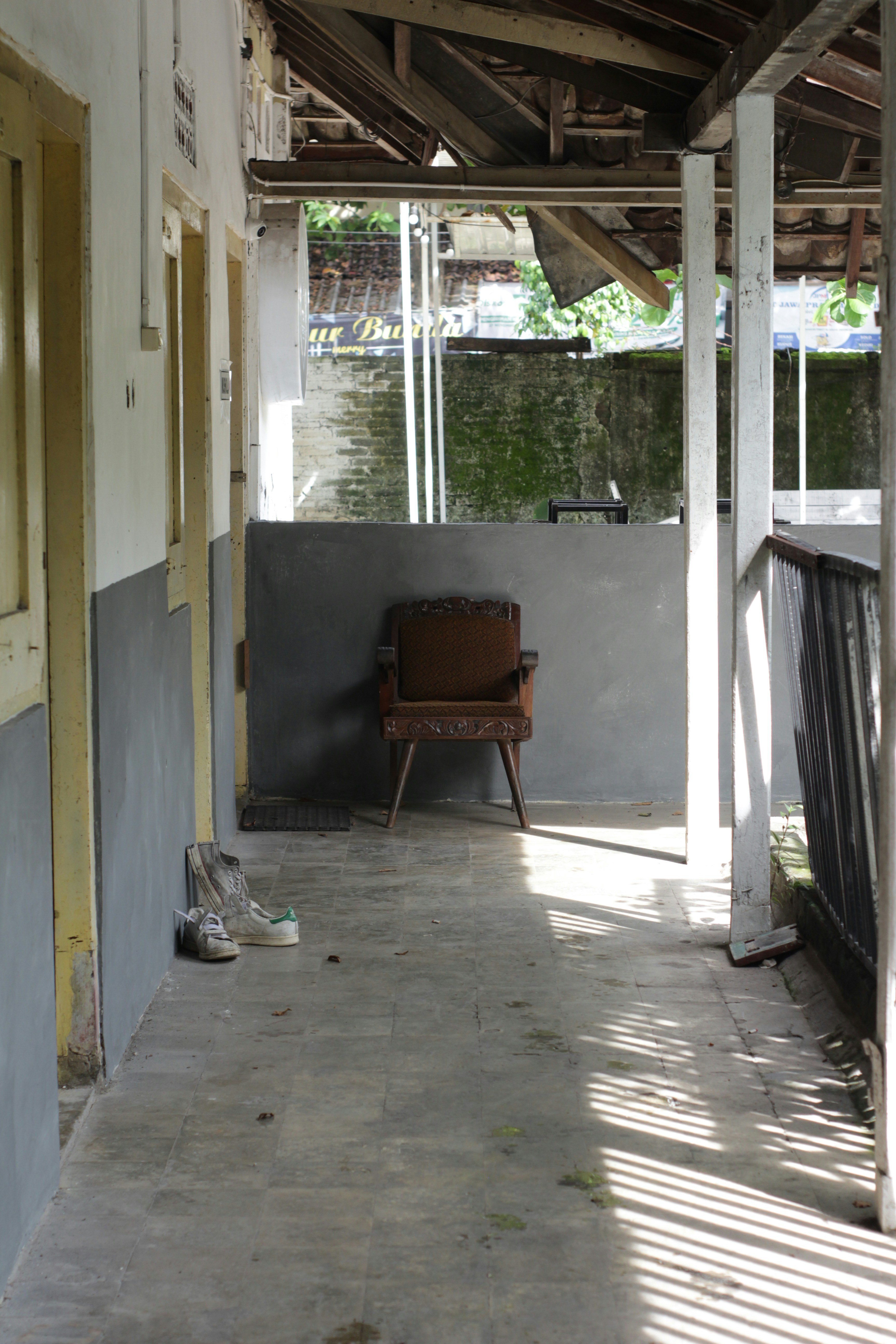 A chair sitting on a porch under a roof photo – Free Grey Image on Unsplash