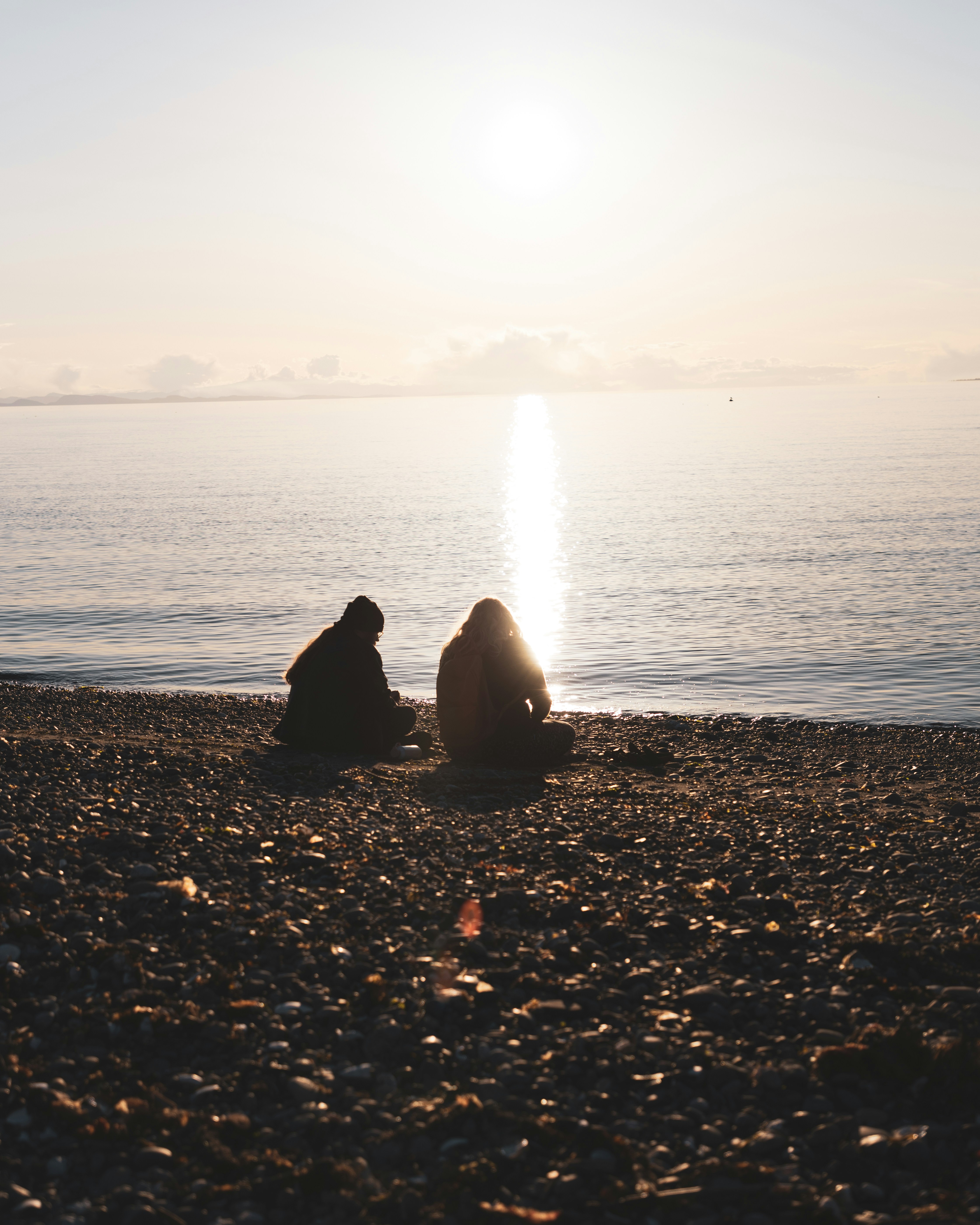 Un couple de personnes assis au sommet d’une plage de sable photo ...