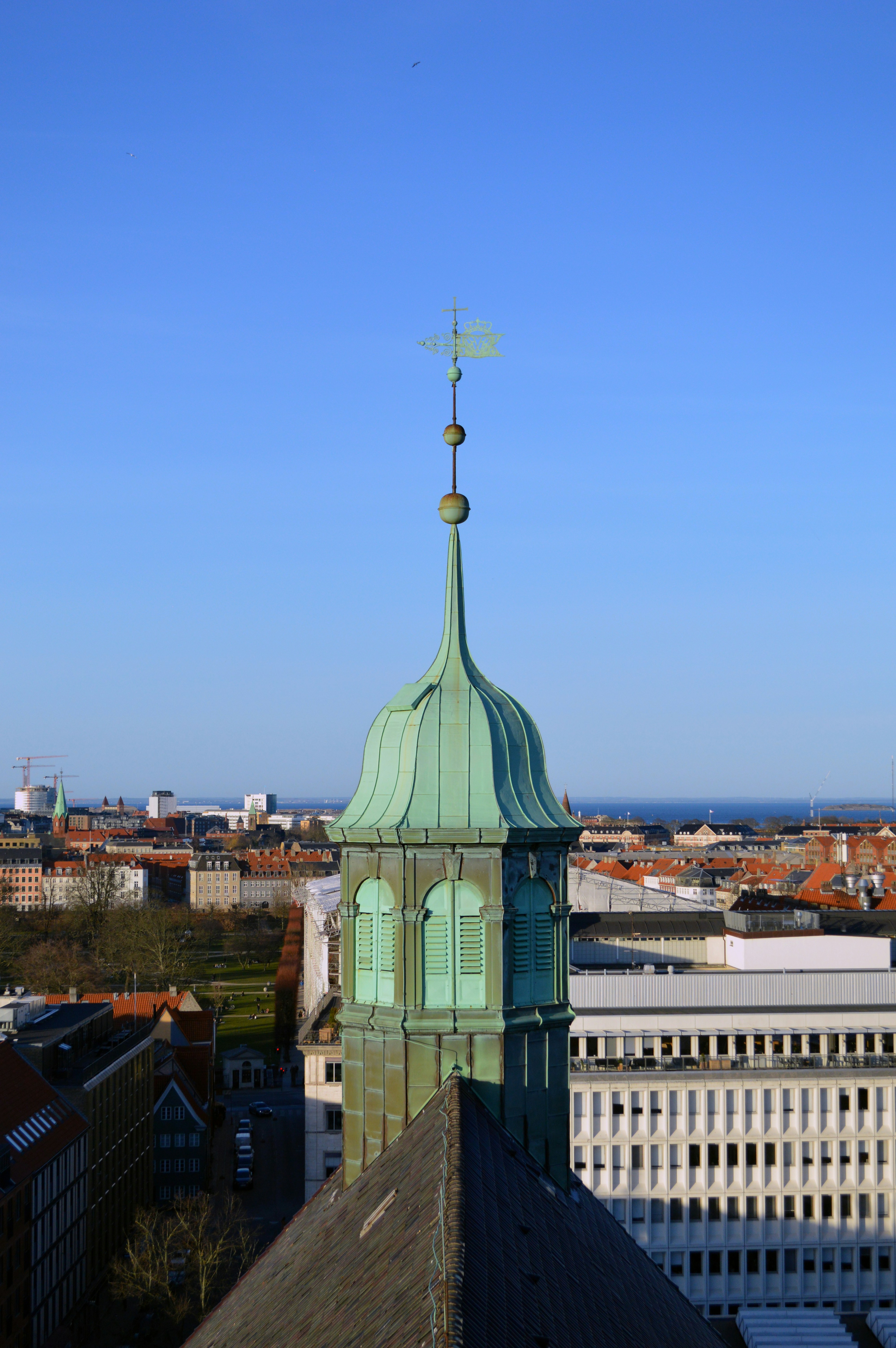 A tall green tower with a weather vane on top of it photo – Free ...
