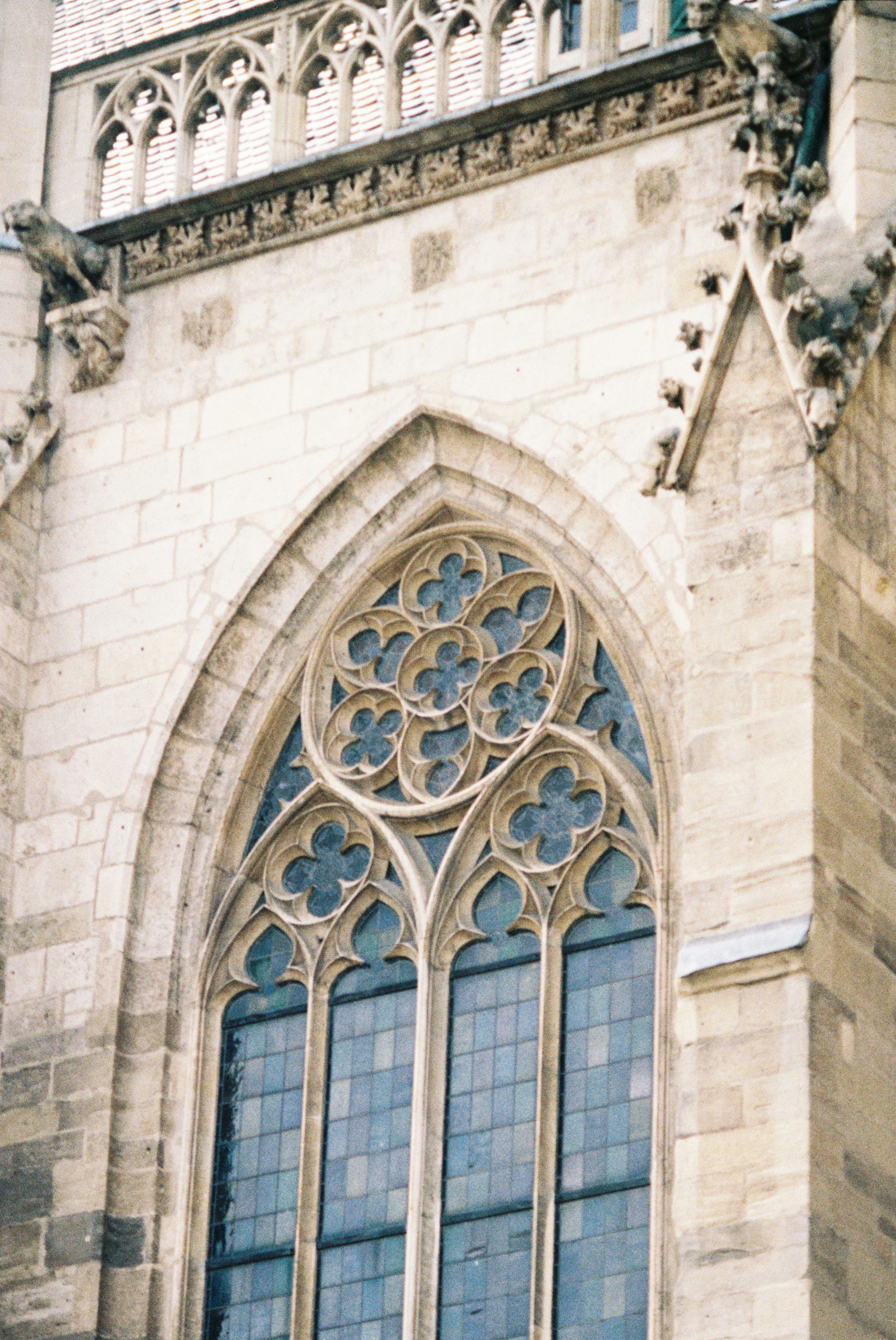 Intricate Gothic window design featuring detailed stonework and stained glass. The craftsmanship highlights the artistry of historical architecture.