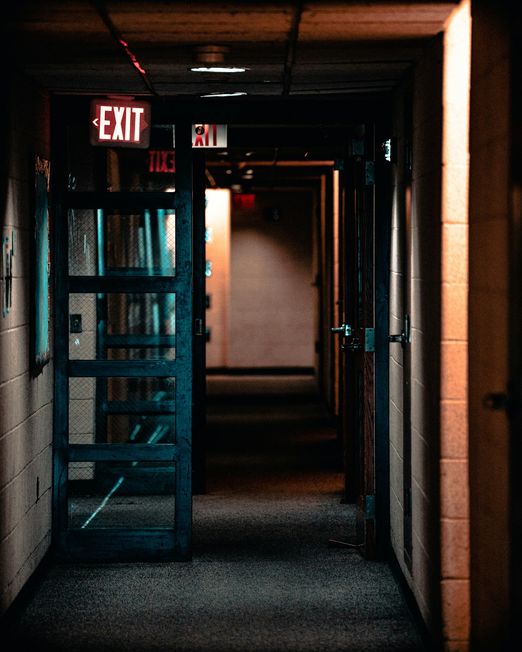 A hallway with a exit sign next to a book shelf photo – Free Temple ...