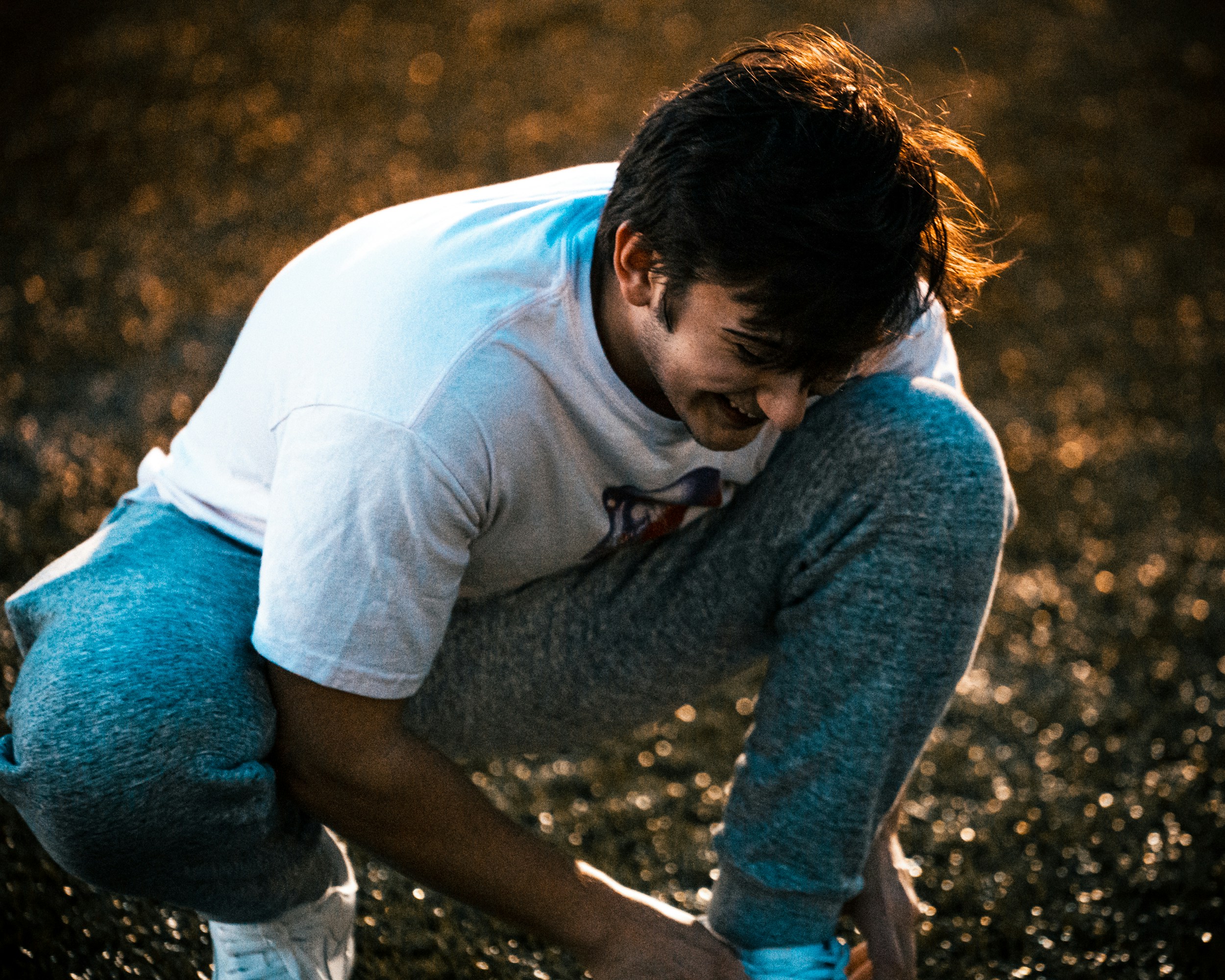 A man kneeling down in the grass with his hands on his knees photo ...