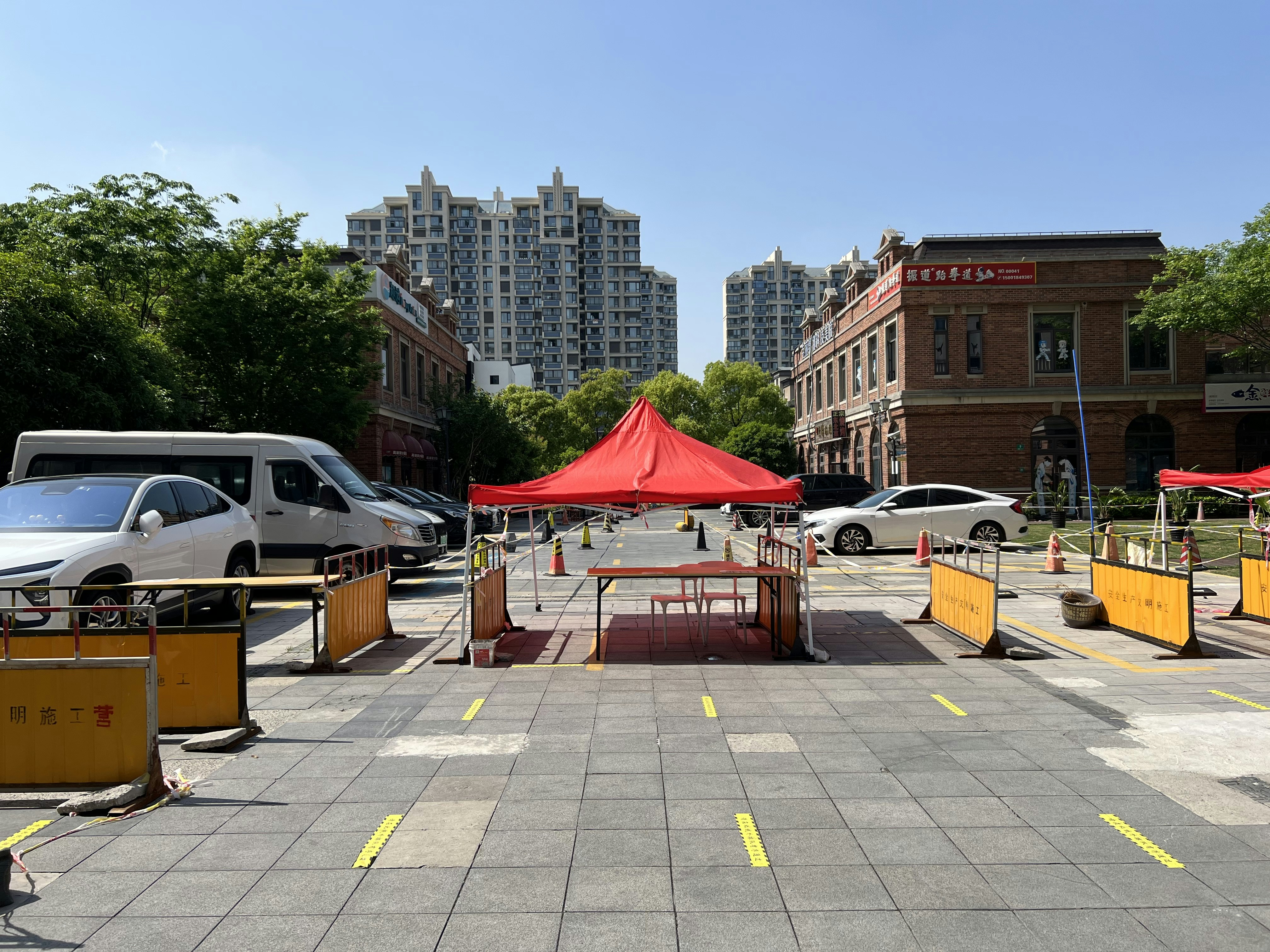 A parking lot with tables and umbrellas in the middle of it photo ...