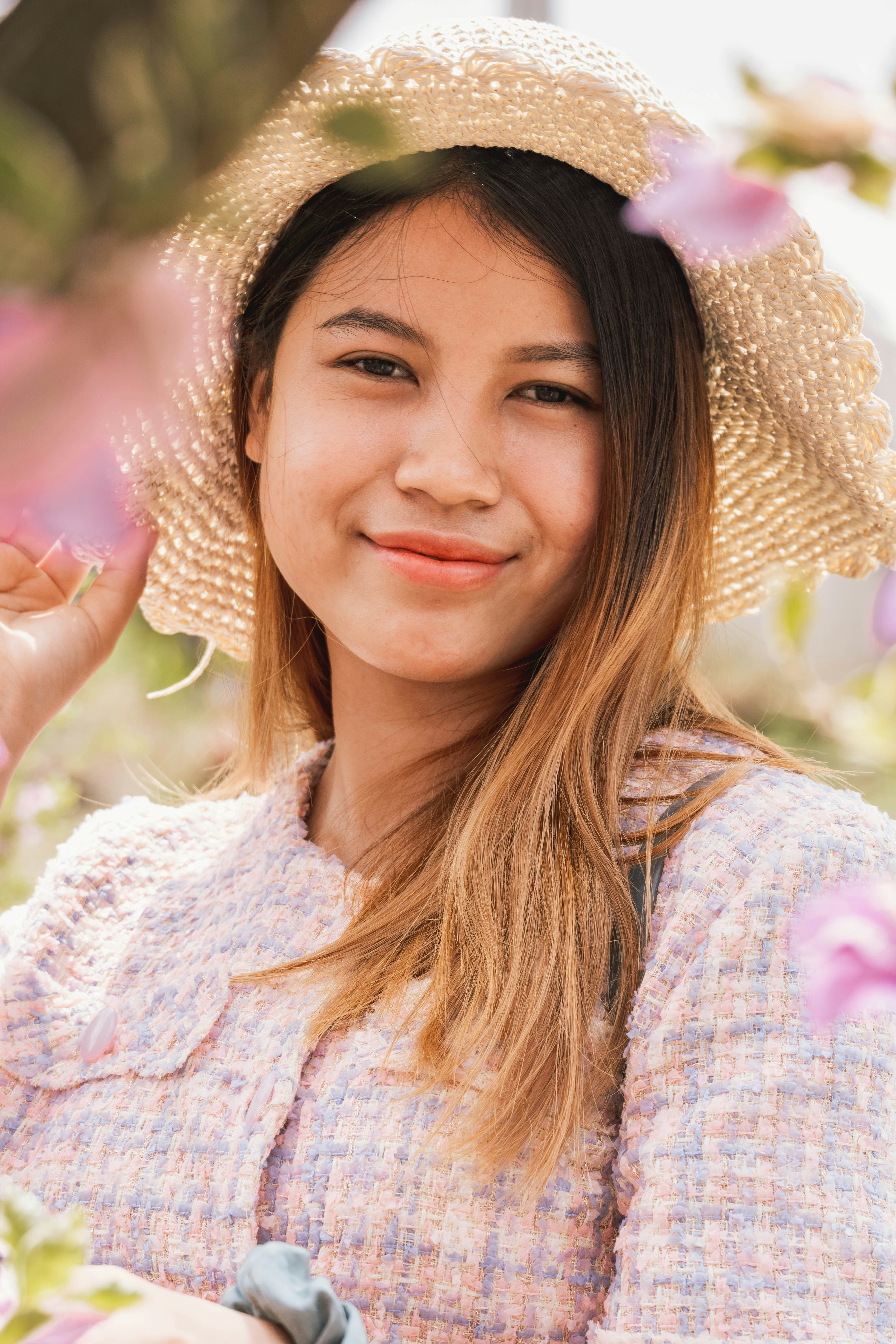 Une jeune femme portant un chapeau de paille dans un champ de fleurs ...