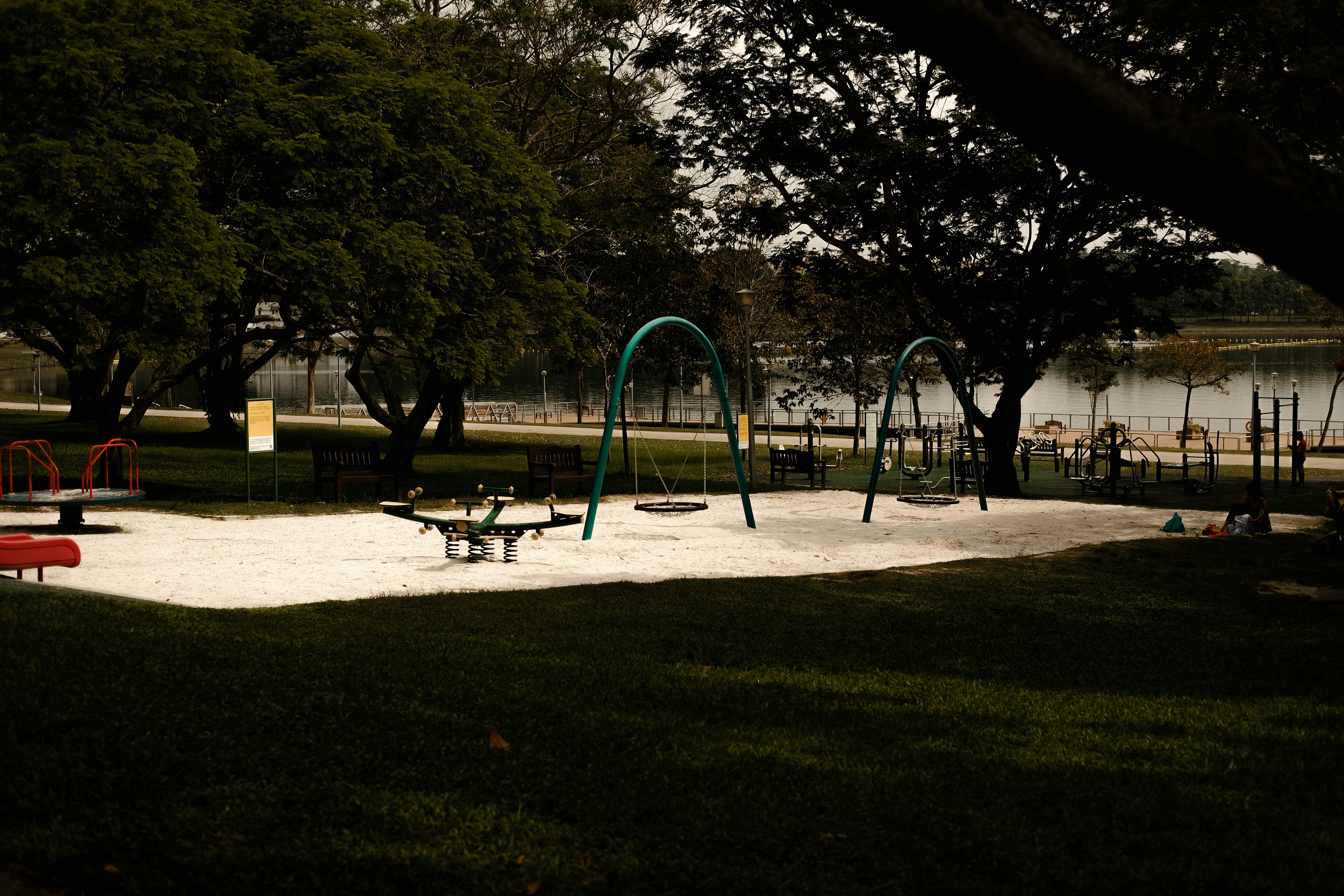 Foto Un parque con un parque infantil y un lago al fondo – Imagen Patio ...