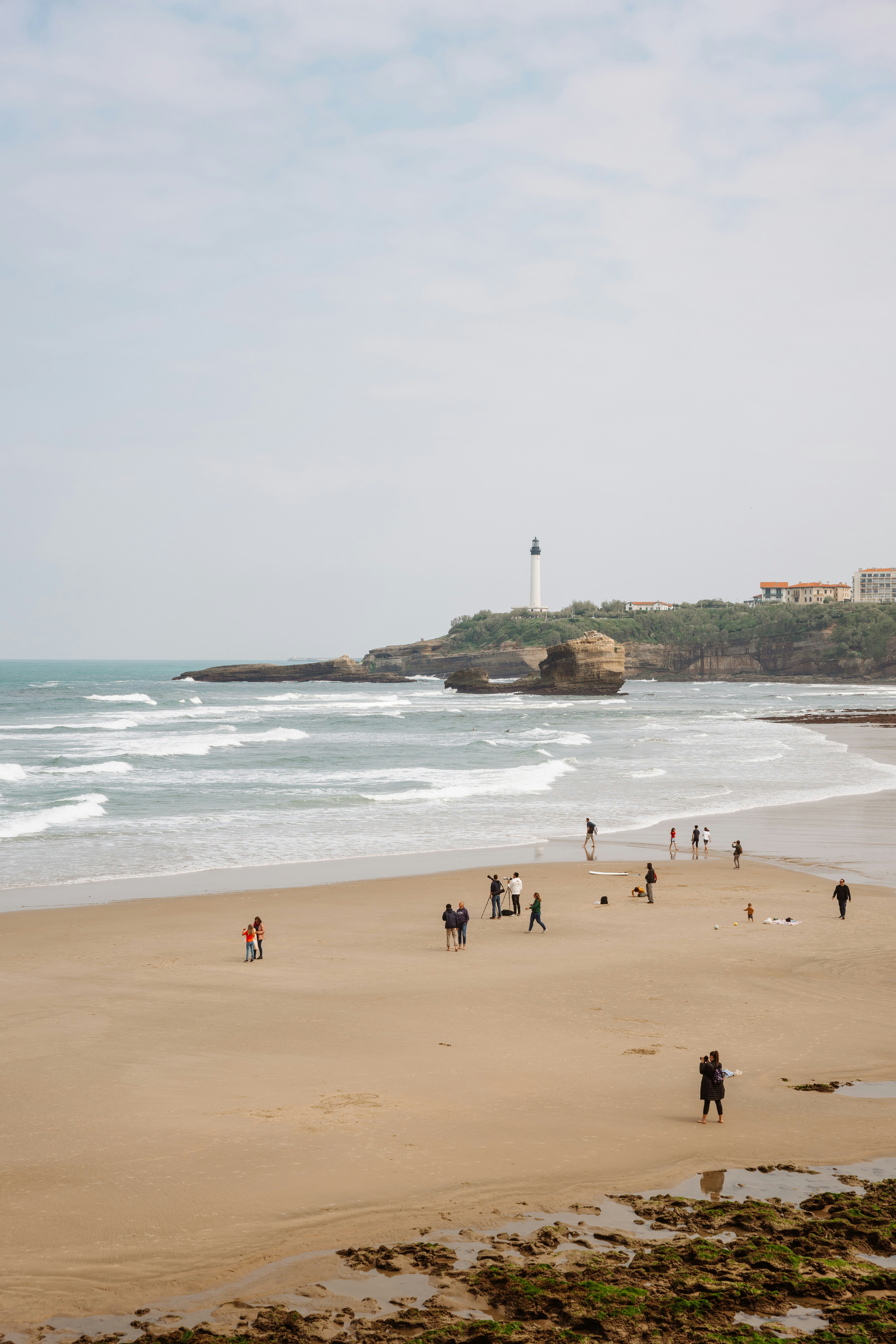A group of people standing on top of a sandy beach photo – Free ...