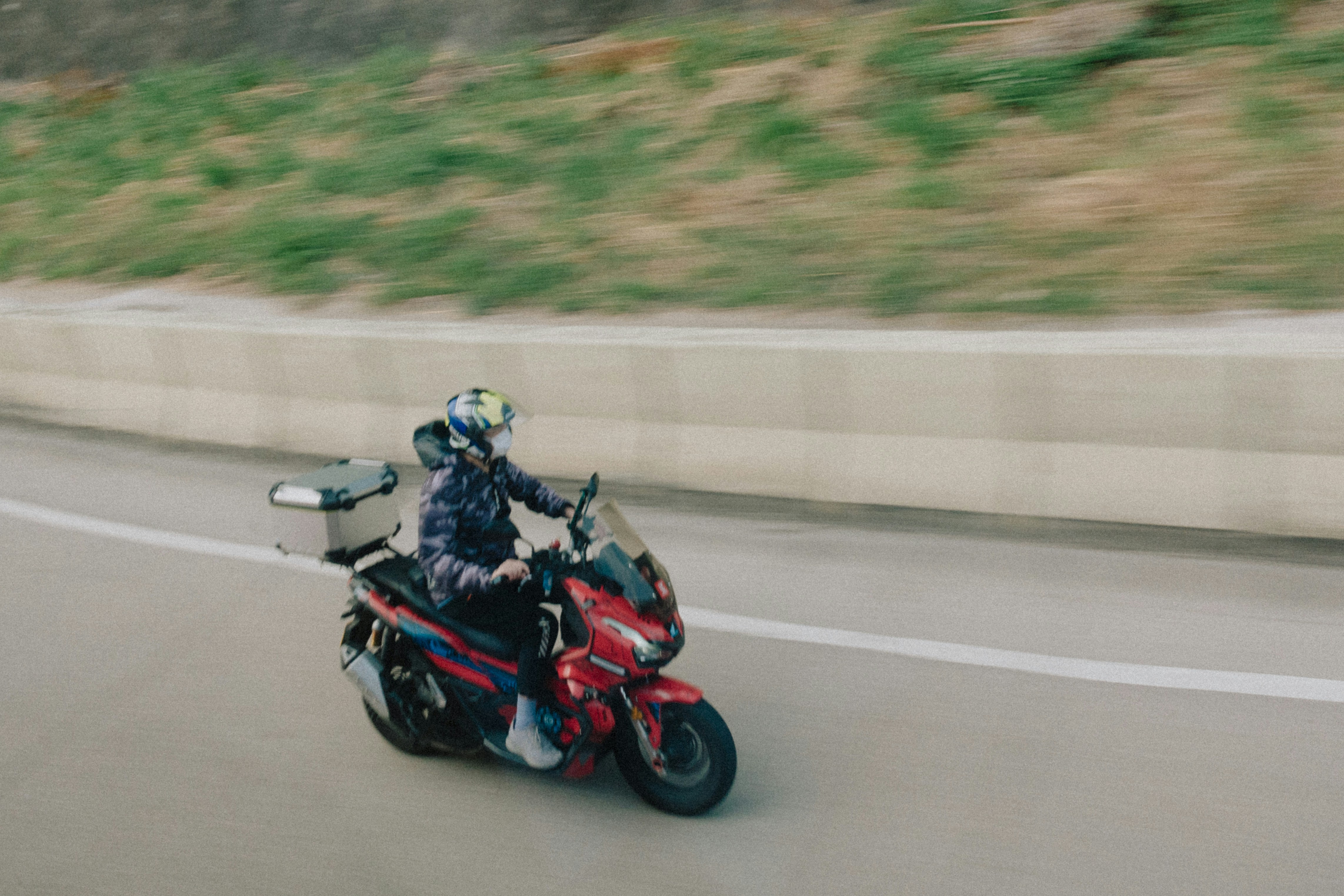 A man riding a red motorcycle down a curvy road photo – Free Road Image ...