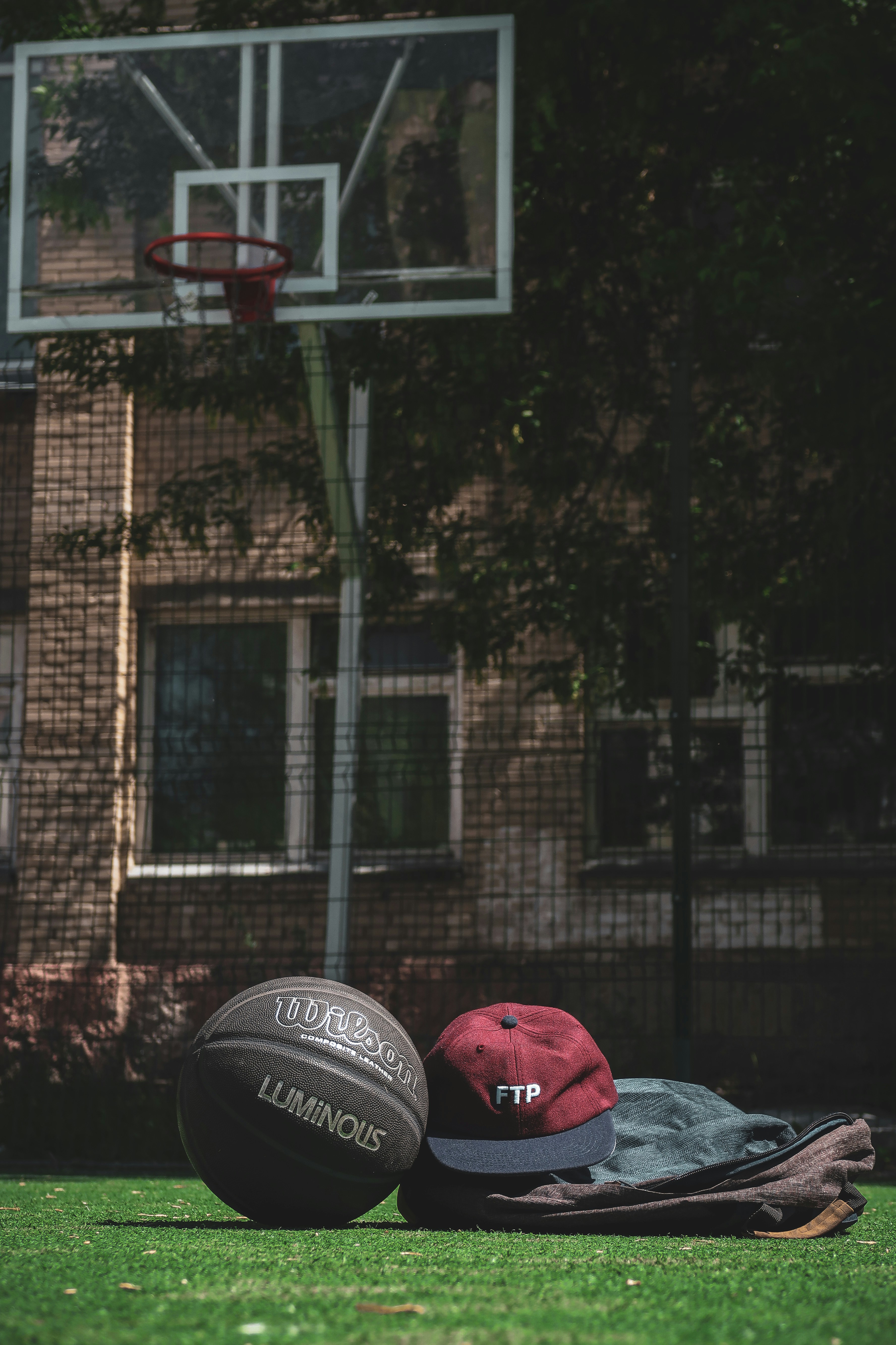 Two basketballs and a hat sitting on a blanket in front of a basketball ...