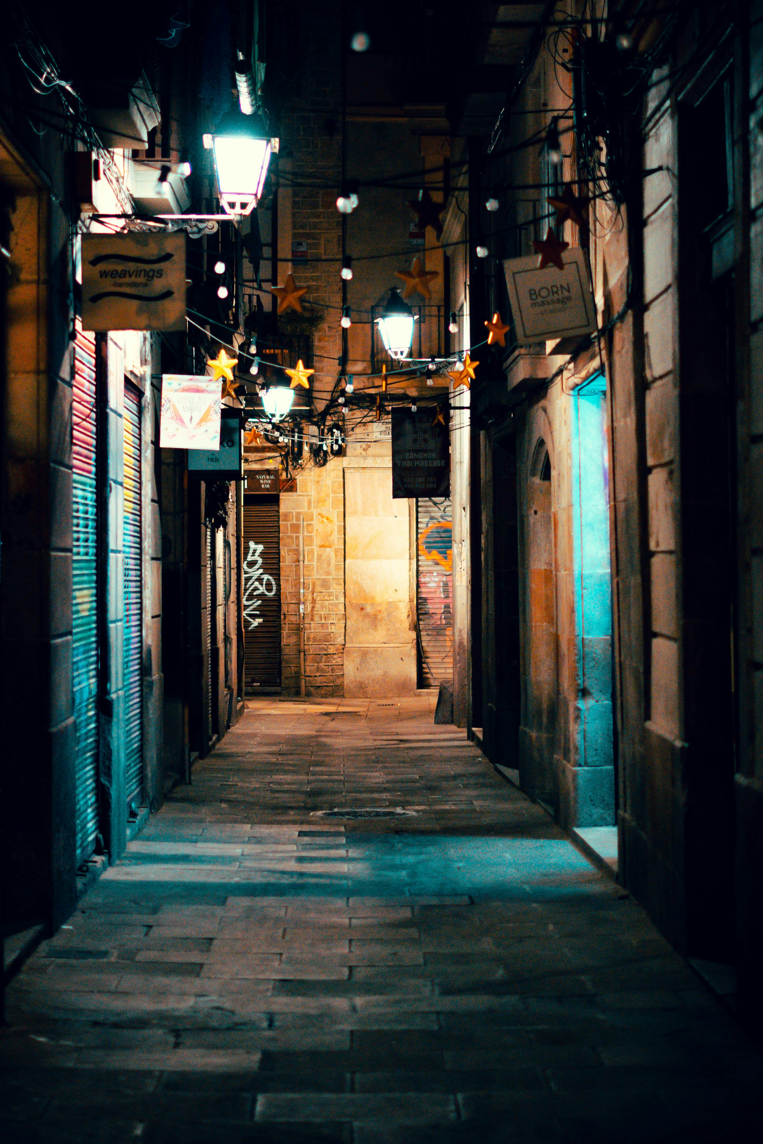 A narrow alleyway with signs on the walls photo – Free Barcelona Image ...