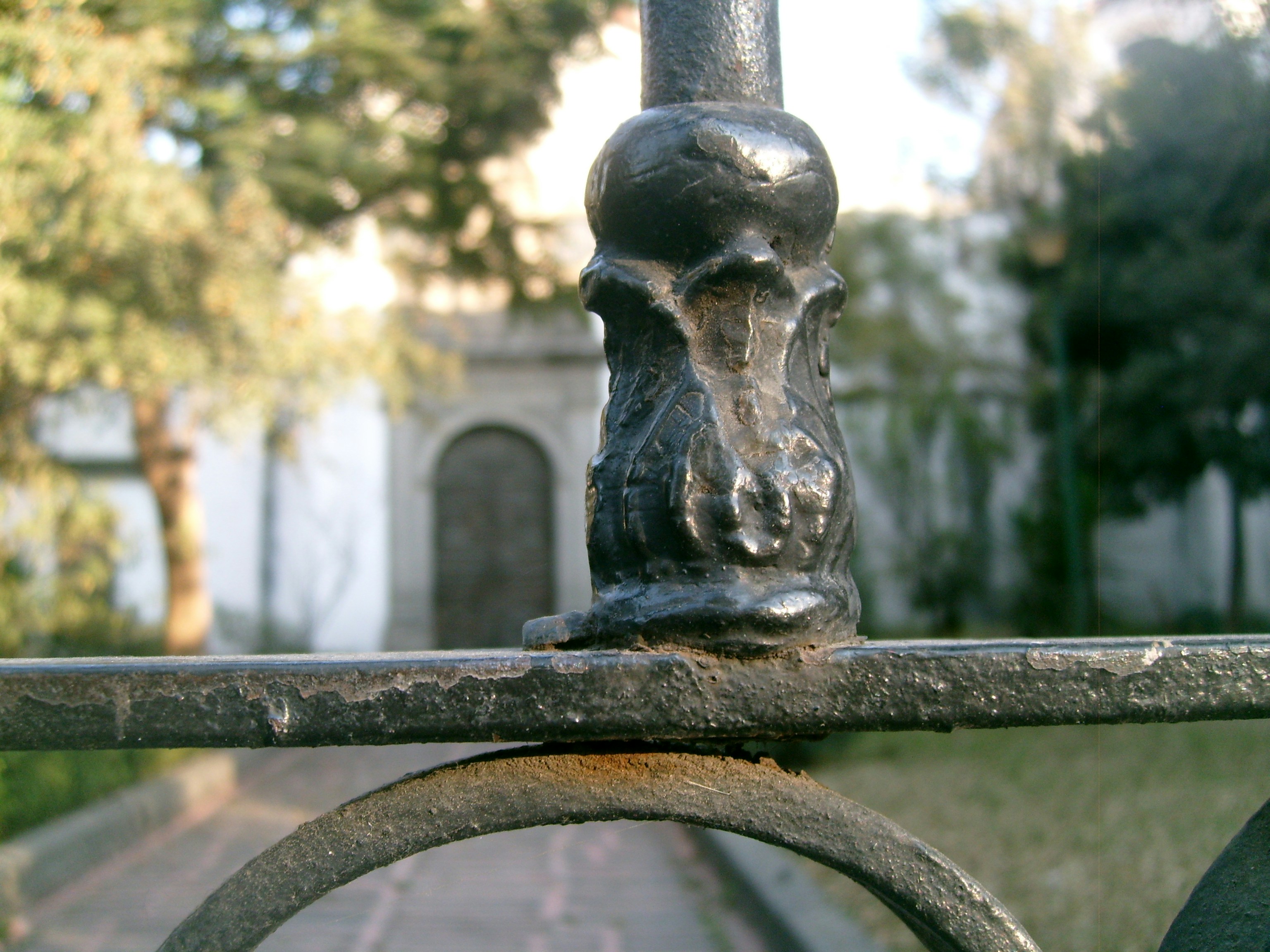 Iron Sentinel Over a Quiet Path: Skull Finial Framing the Scene