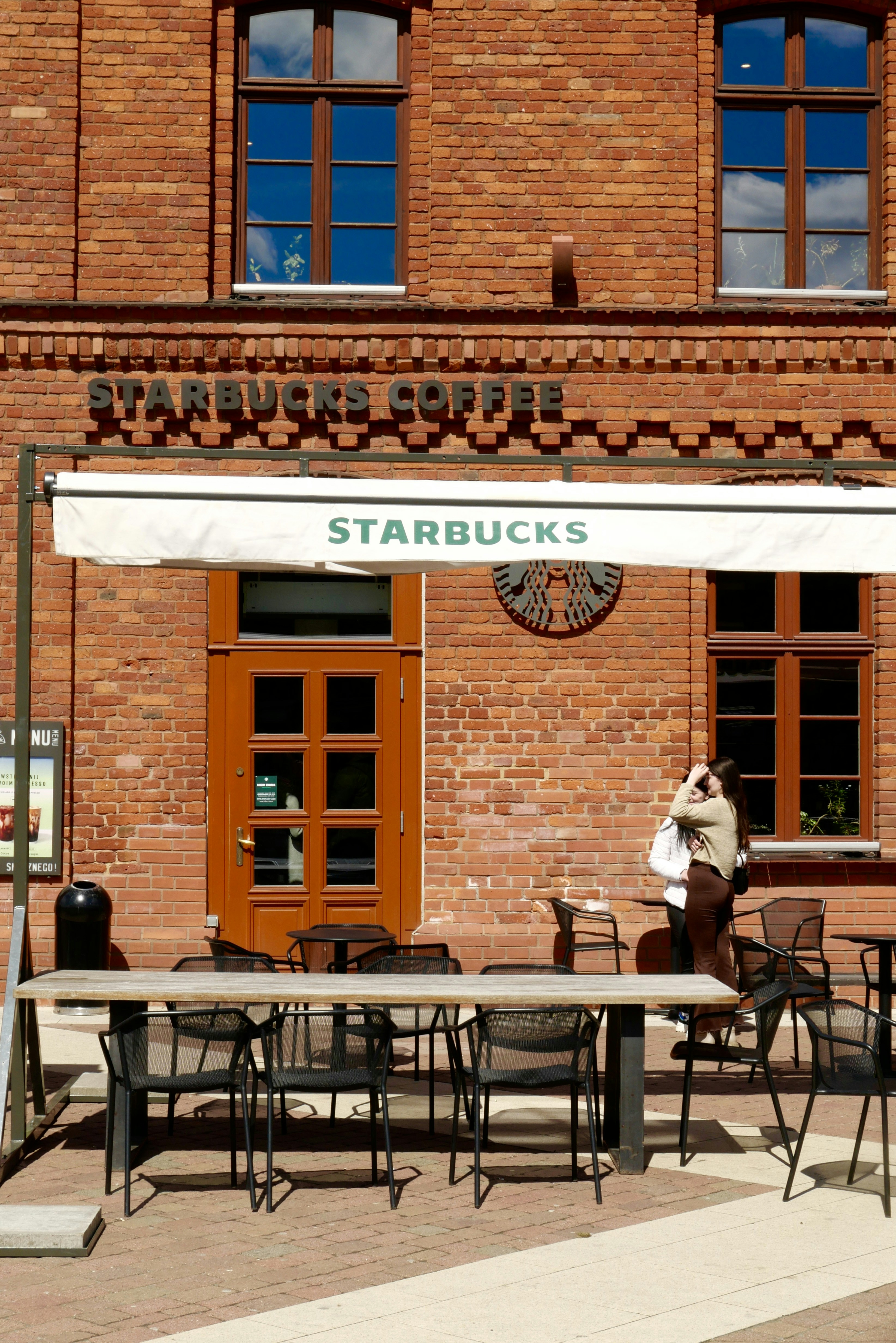 Sunlit Brickfront Starbucks: a solitary moment by the patio
