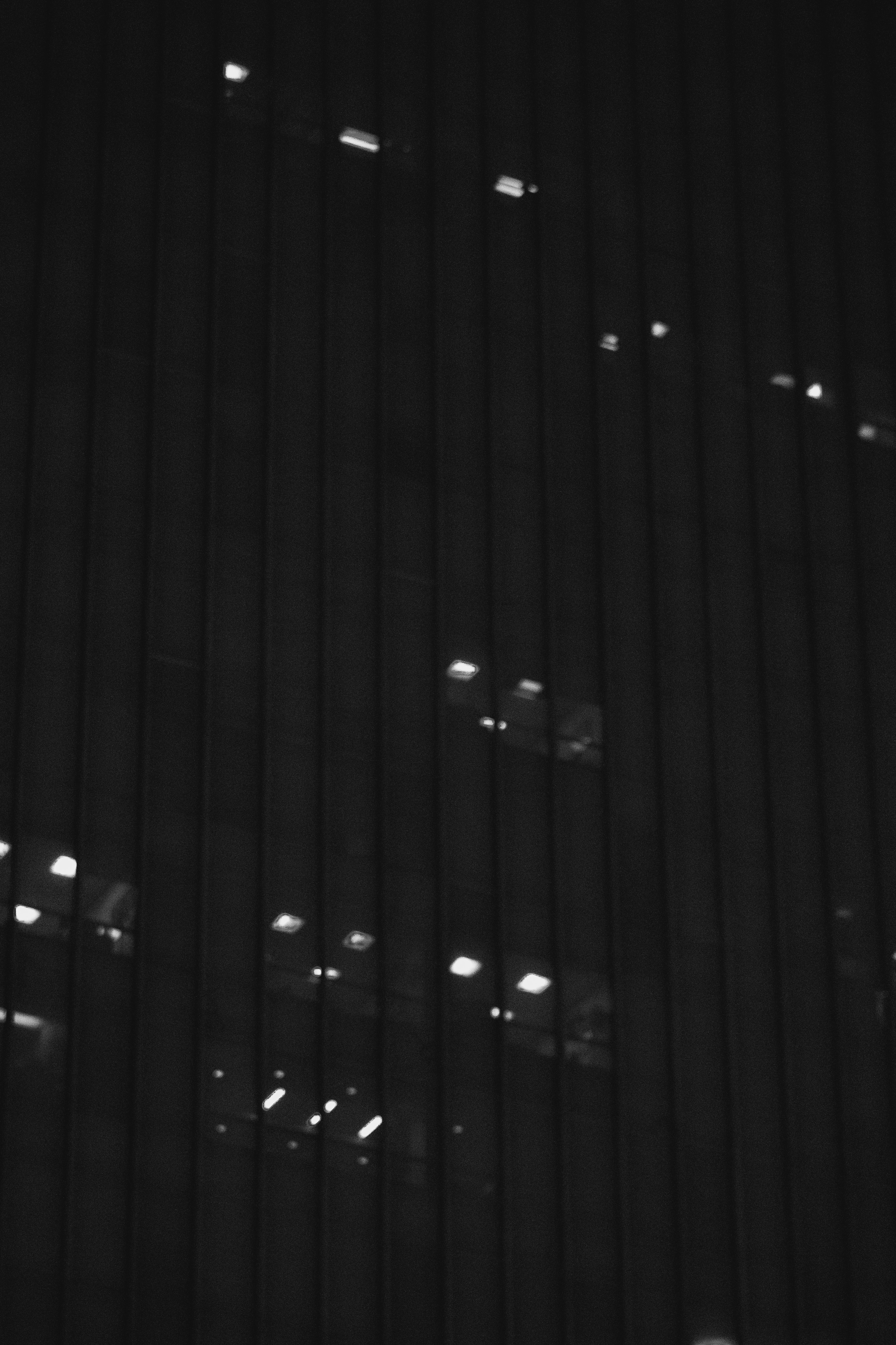 Midnight Grid: Light Fragments Behind Vertical Shutters